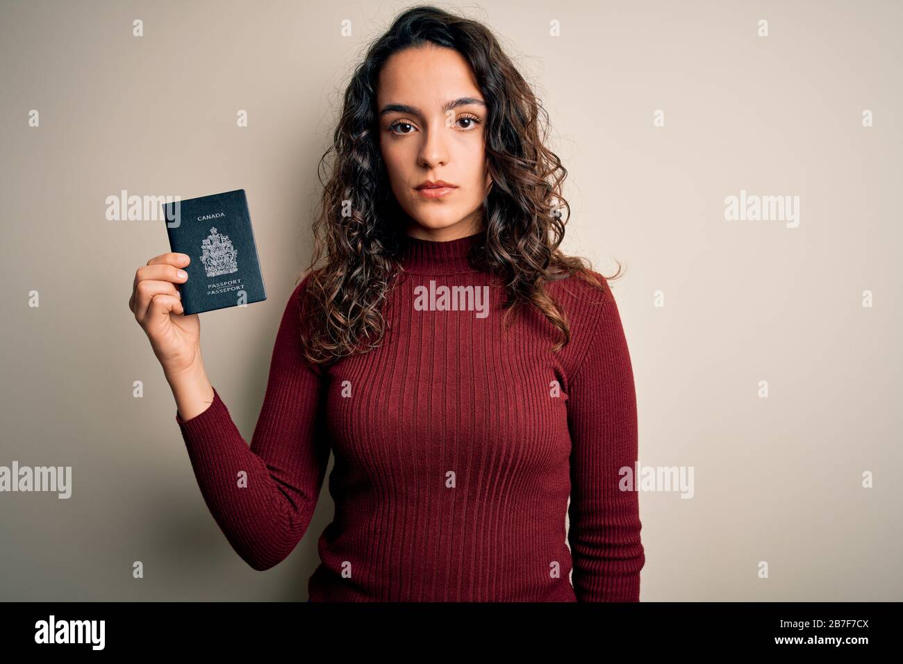 Young beautiful tourist woman with curly hair on vacation holding ...
