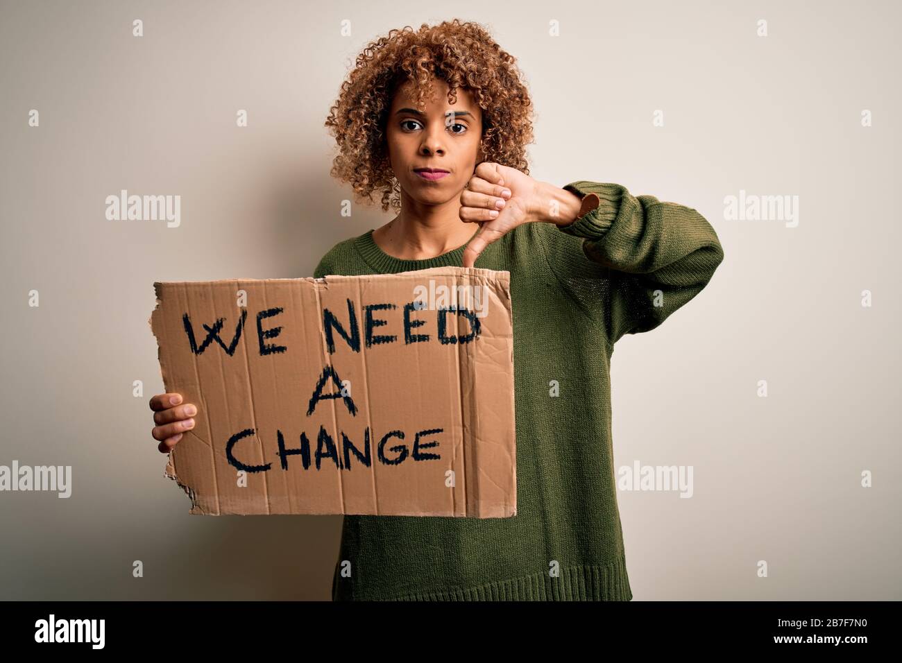 Young african american activist woman asking for change holding banner ...