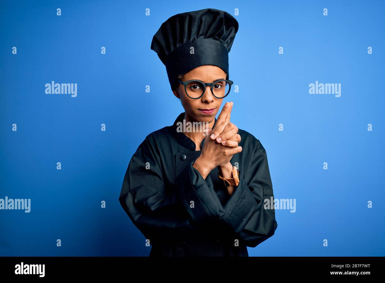 Young african american chef woman wearing cooker uniform and hat over ...