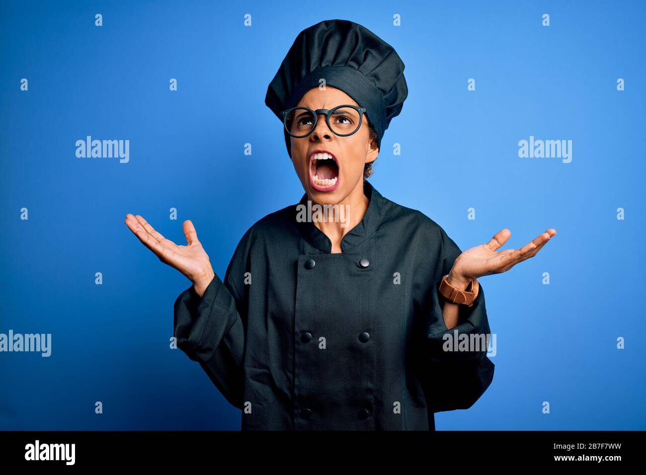 Young african american chef woman wearing cooker uniform and hat over ...