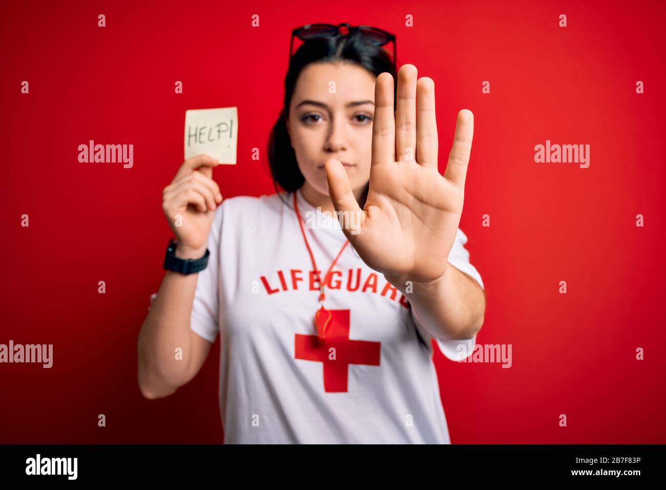 Young lifeguard woman holding paper note with help word over red ...