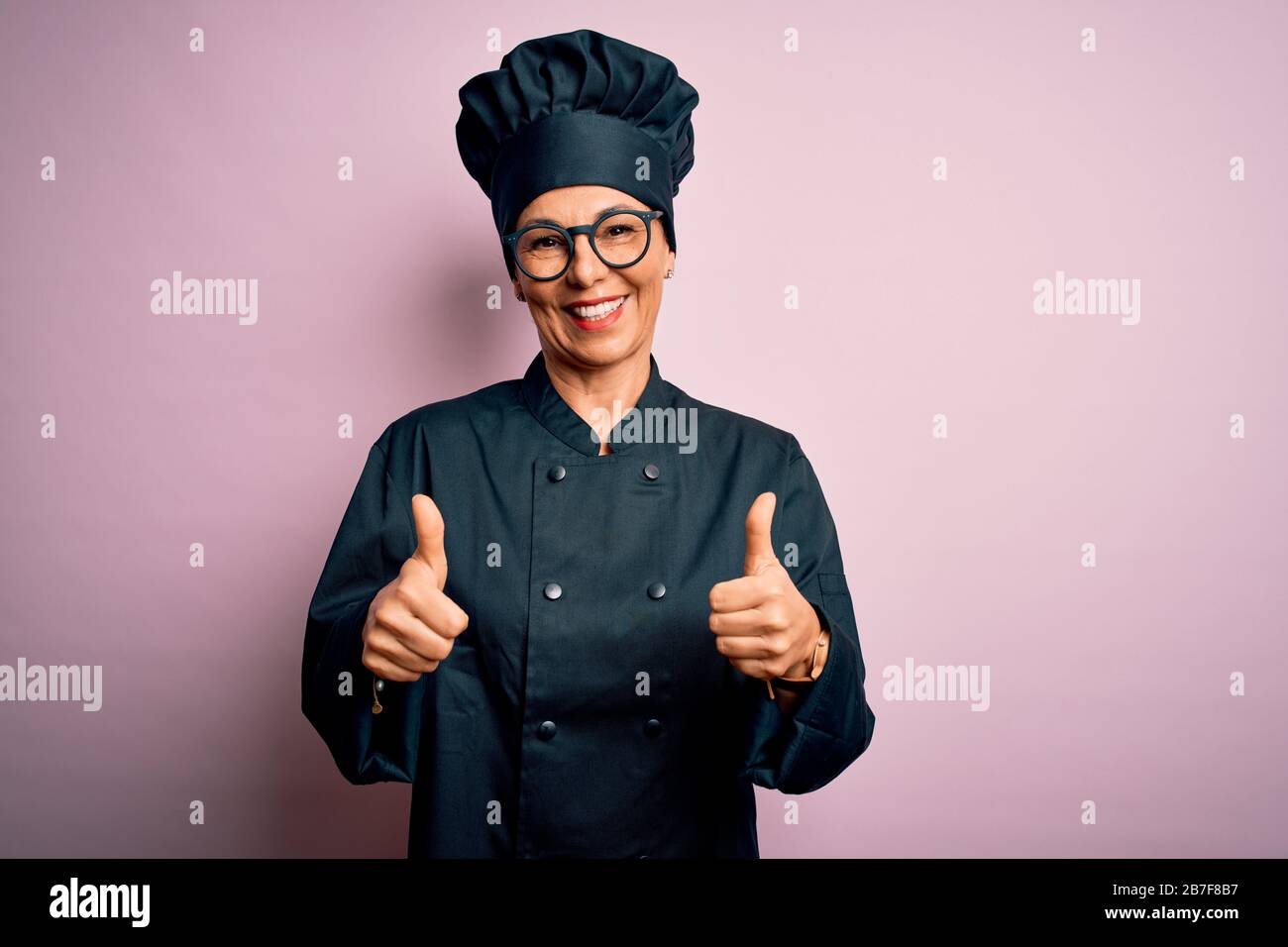 Middle age brunette chef woman wearing cooker uniform and hat over ...