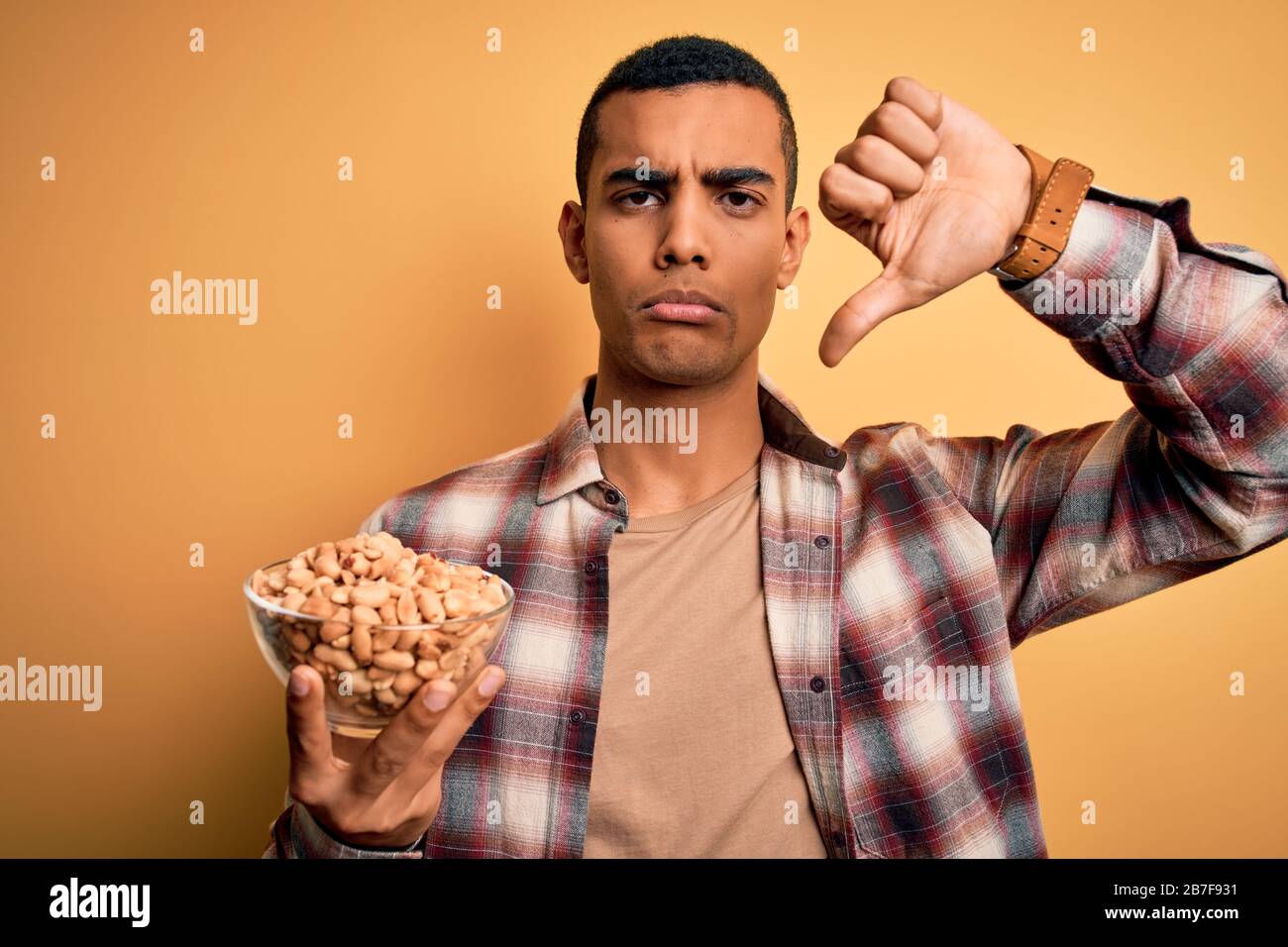 Handsome african american man holding bowl with heathy peanuts over ...