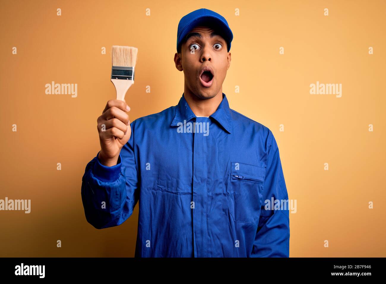 Young handsome african american painter man wearing uniform using ...