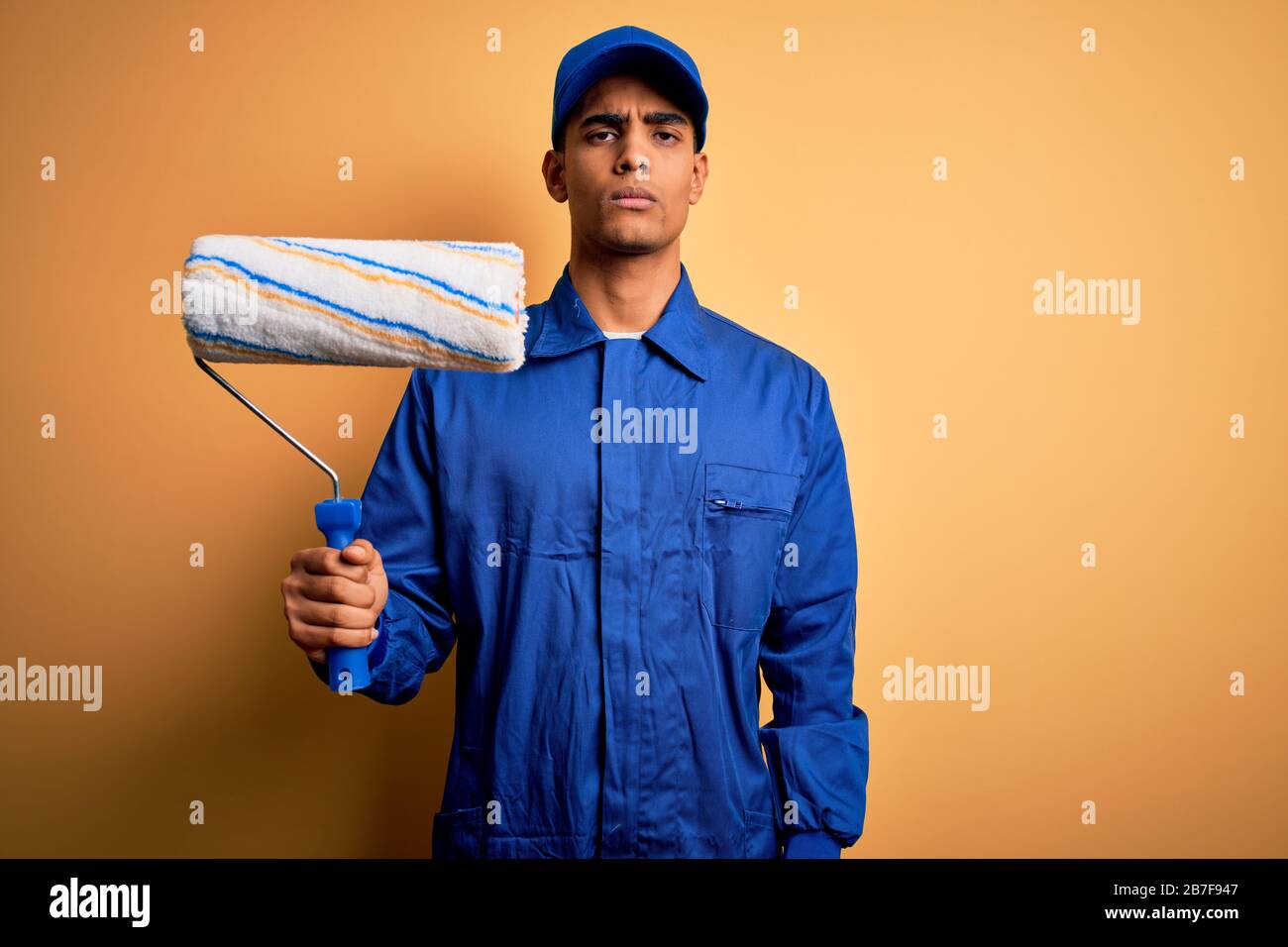 Young handsome african american painter man wearing uniform using ...