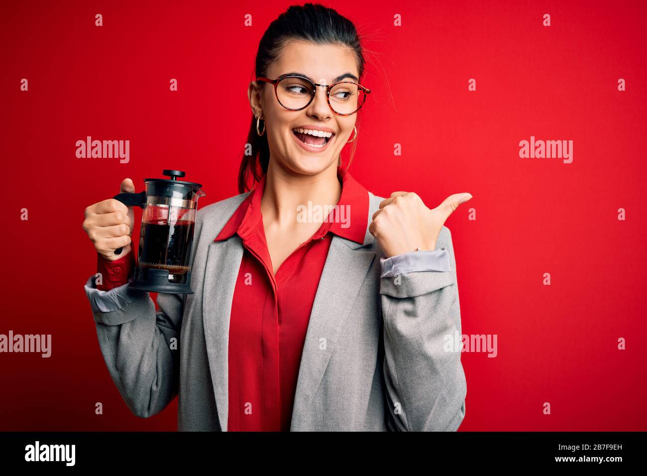 Young beautiful brunette woman doing coffe holding french coffeemaker ...