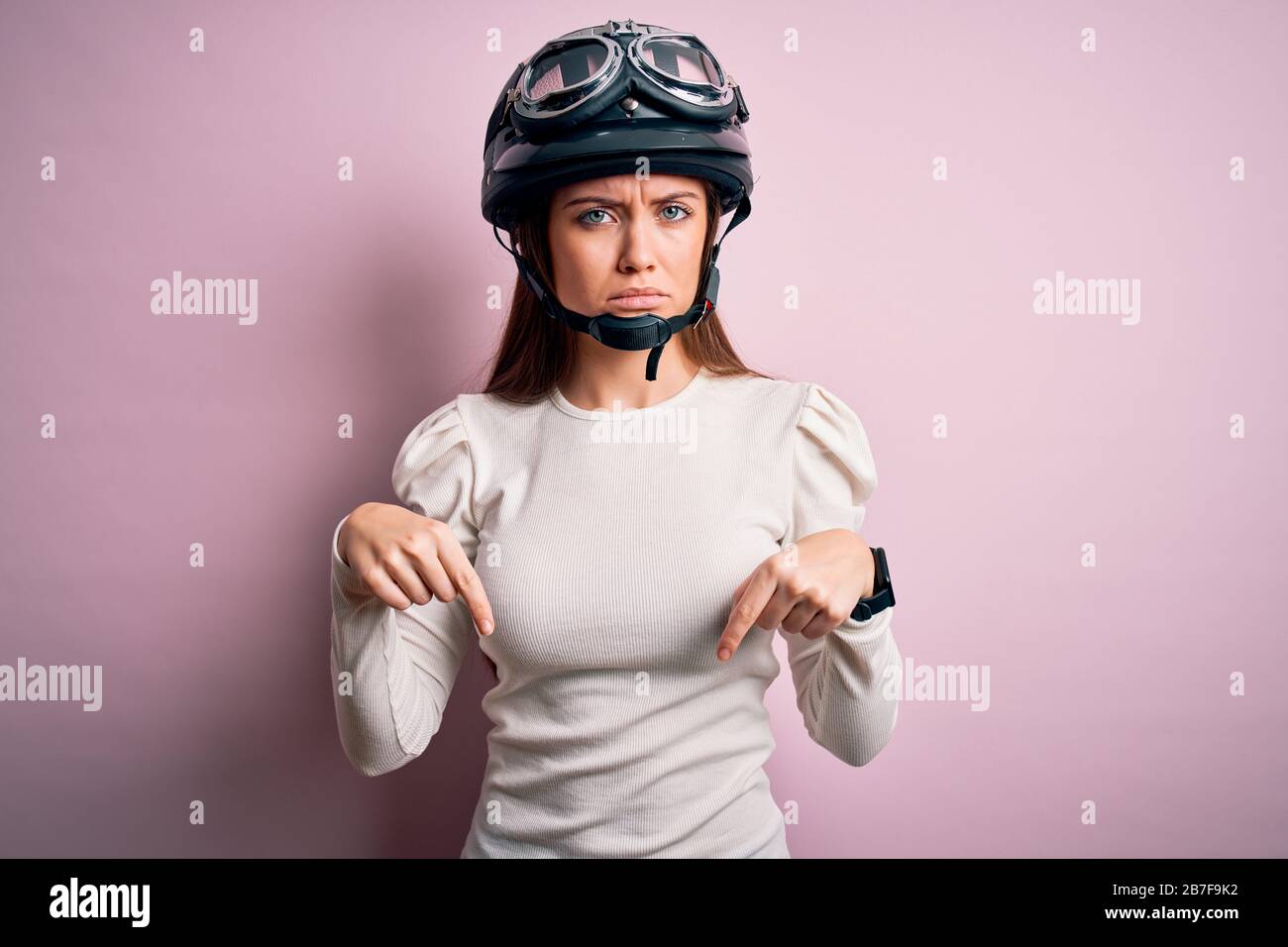 Young beautiful motorcyclist woman with blue eyes wearing moto helmet ...