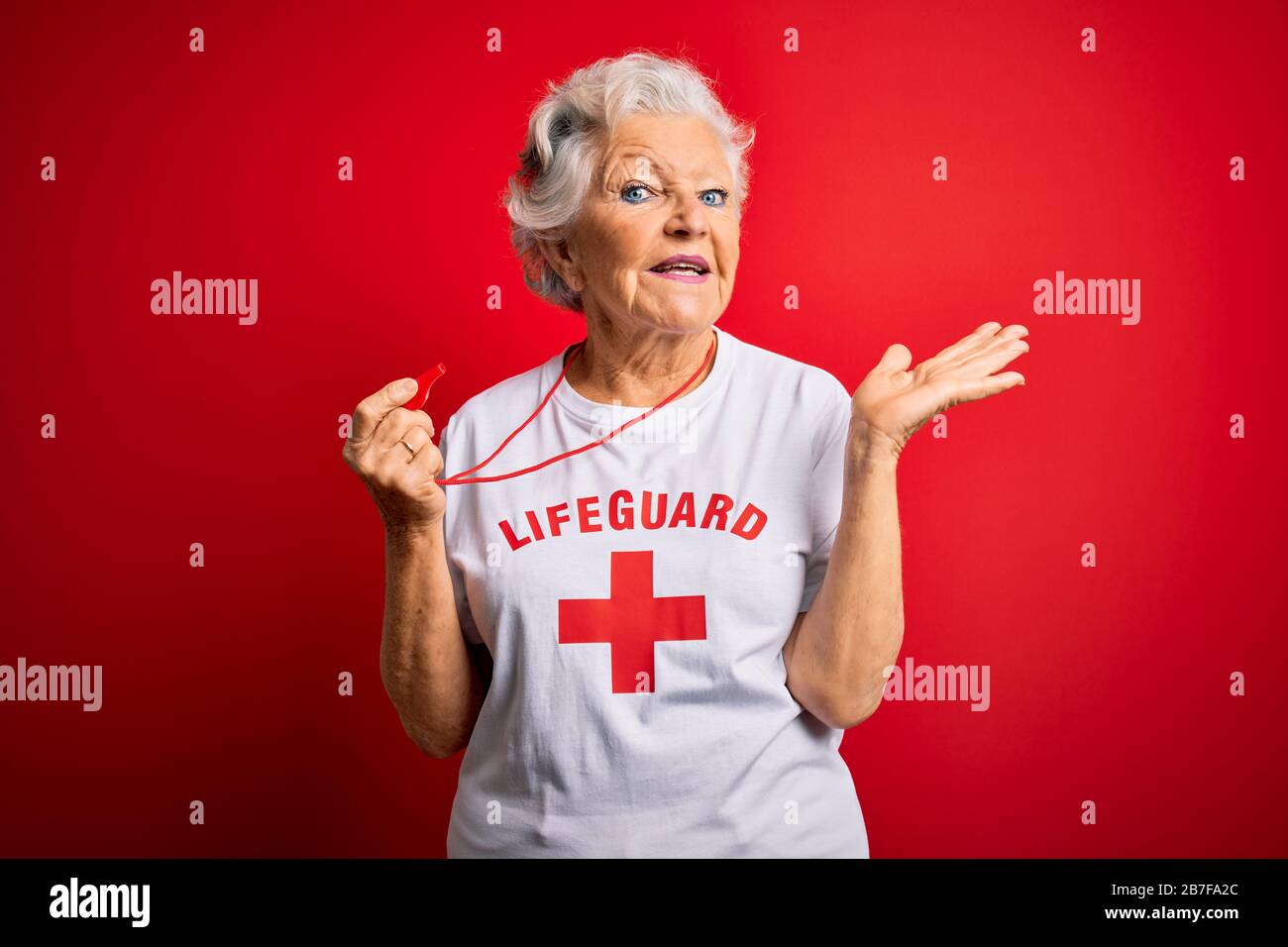 Senior beautiful grey-haired lifeguard woman wearing t-shirt with red ...