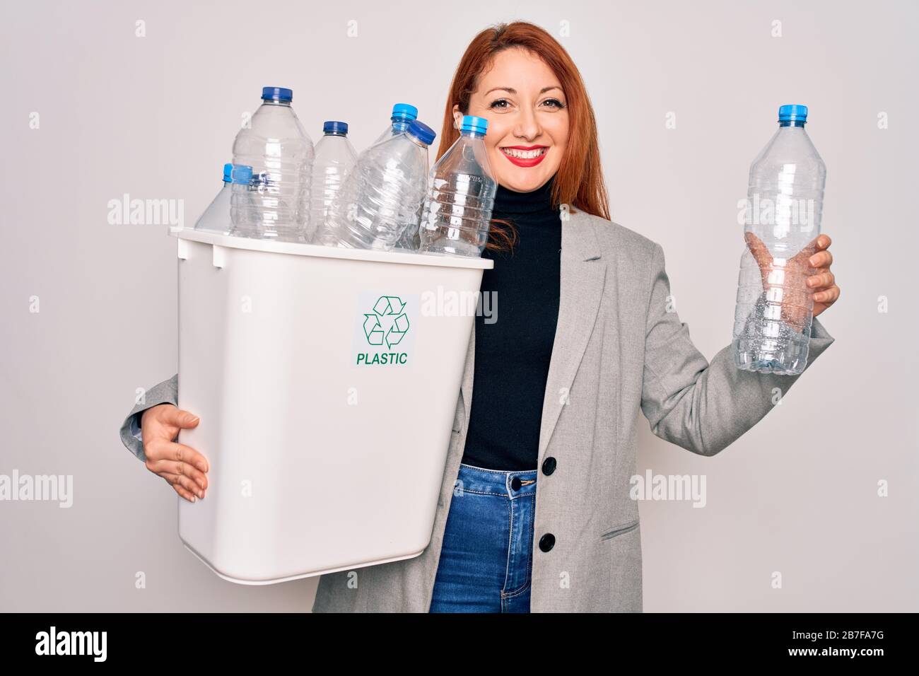 Young beautiful redhead woman recycling holding trash can with plastic ...