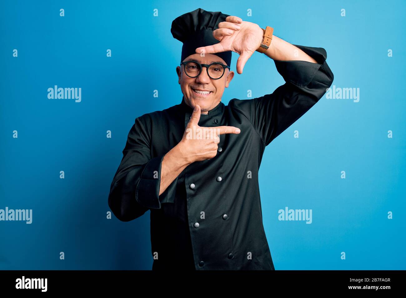 Middle age handsome grey-haired chef man wearing cooker uniform and hat ...