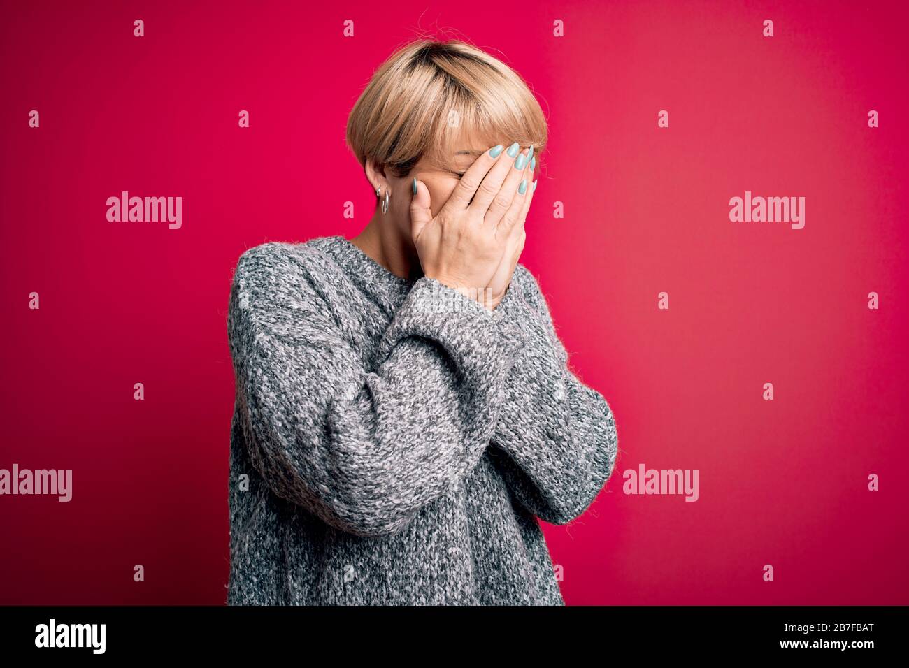 Young blonde woman with modern short hair wearing casual sweater over ...