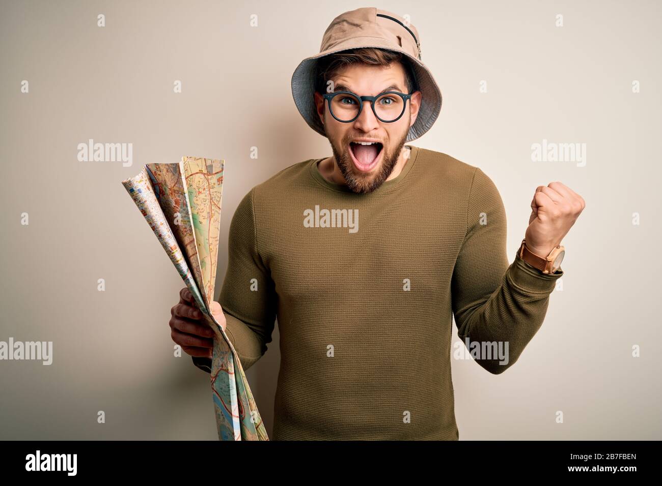 Young blond explorer man with beard and blue eyes wearing glasses and ...