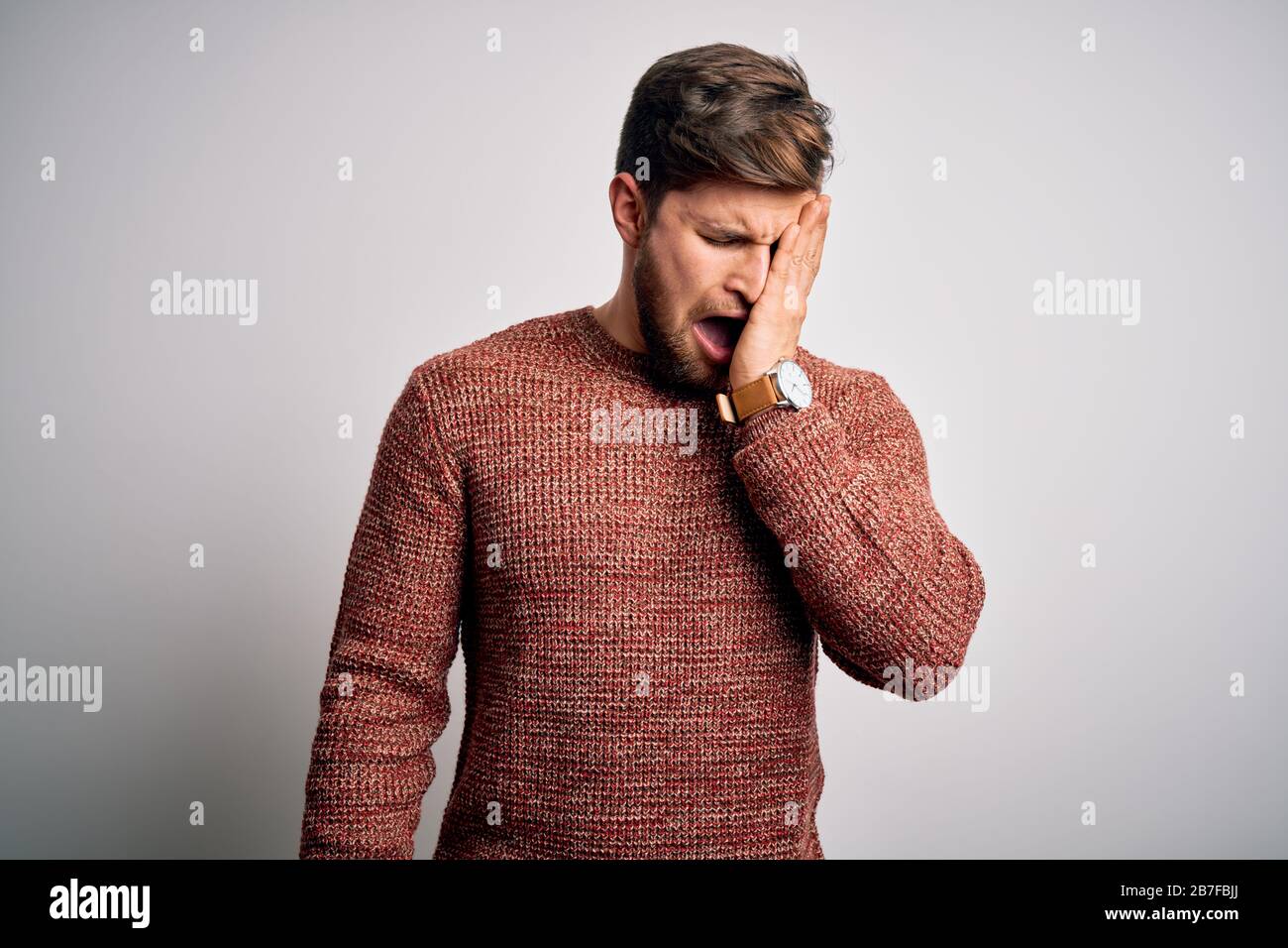 Young blond man with beard and blue eyes wearing casual sweater over ...