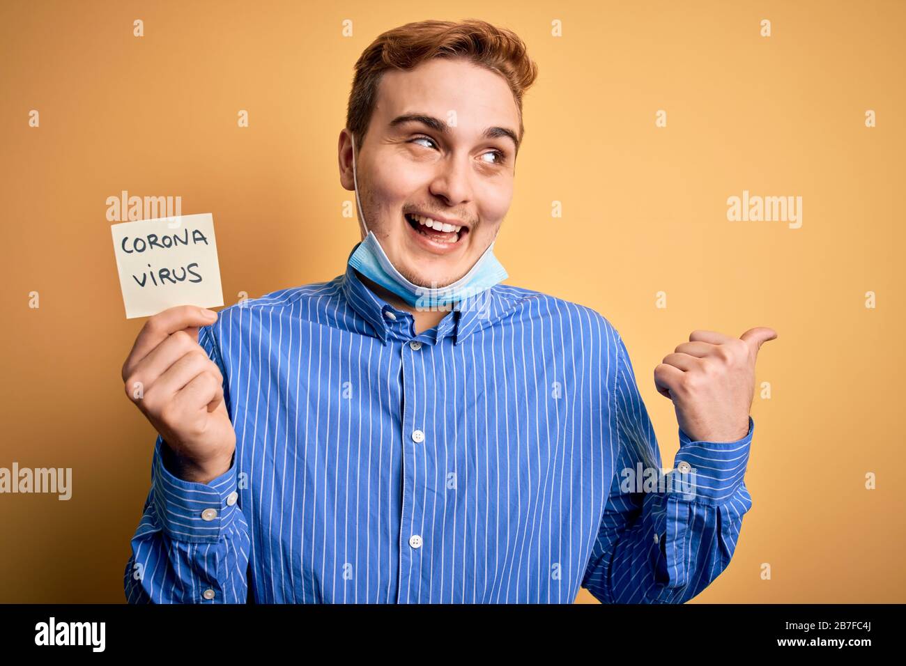 Young man wearing medical security mas holding paper note reminder with ...
