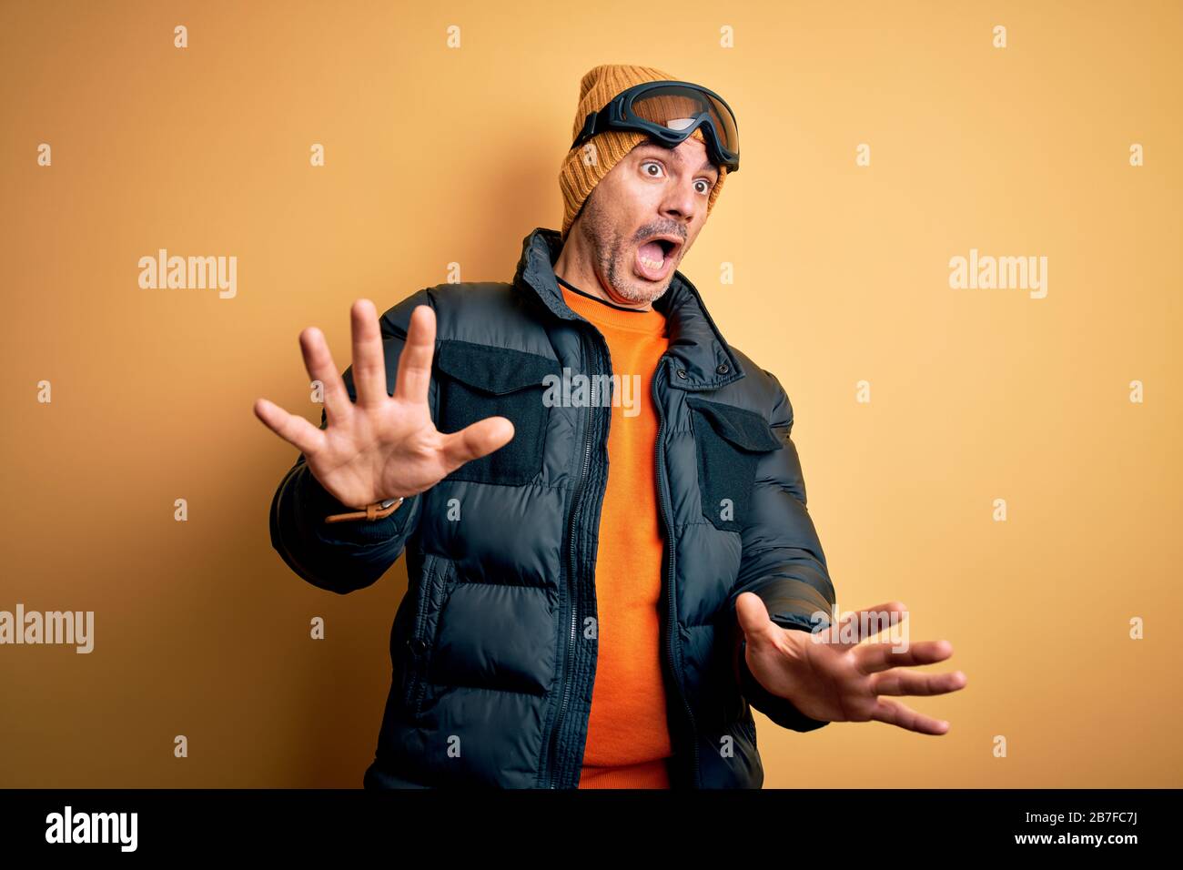 Young handsome skier man skiing wearing snow sportswear using ski ...