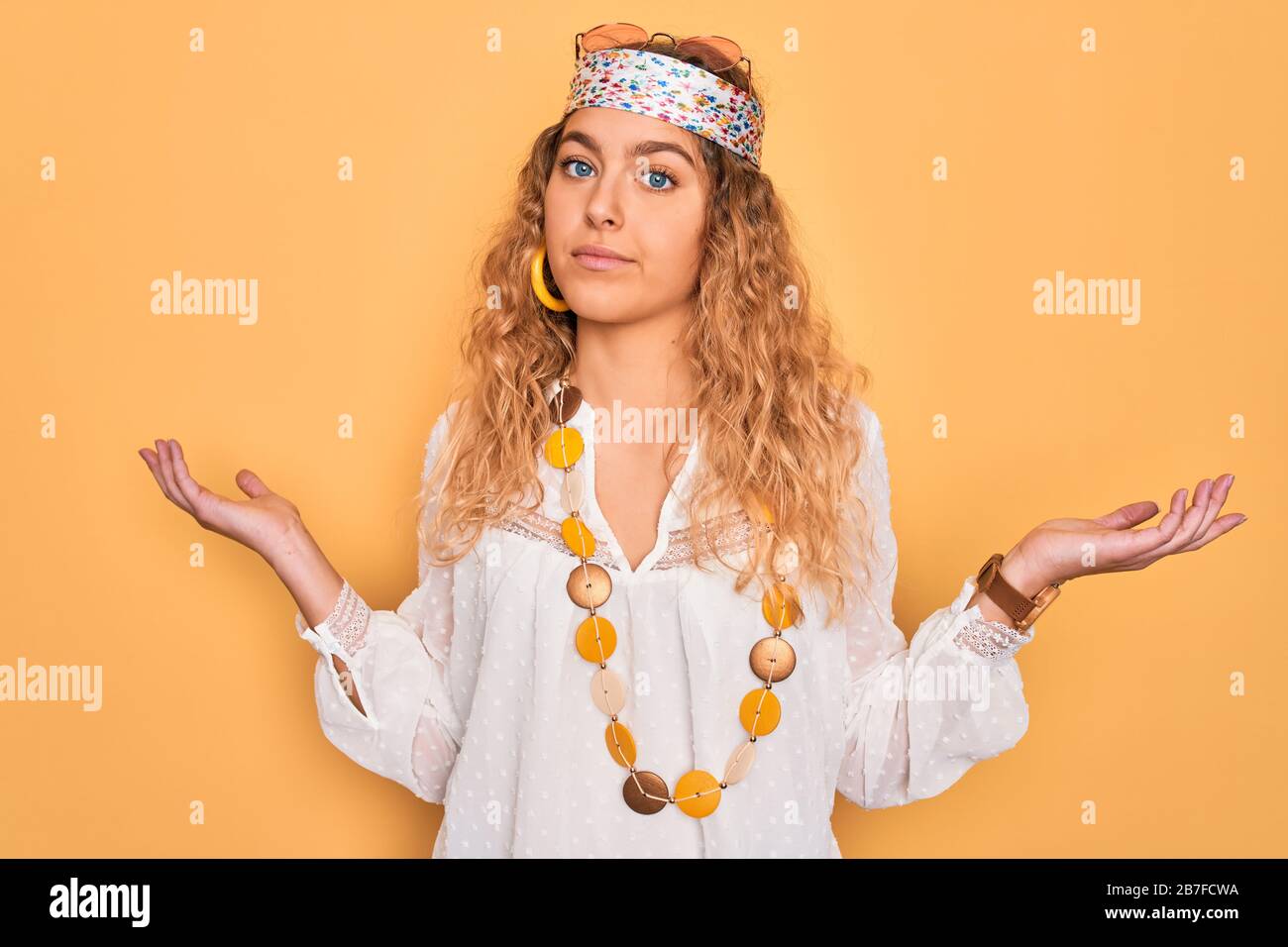 Young beautiful blonde hippie woman with blue eyes wearing sunglasses ...