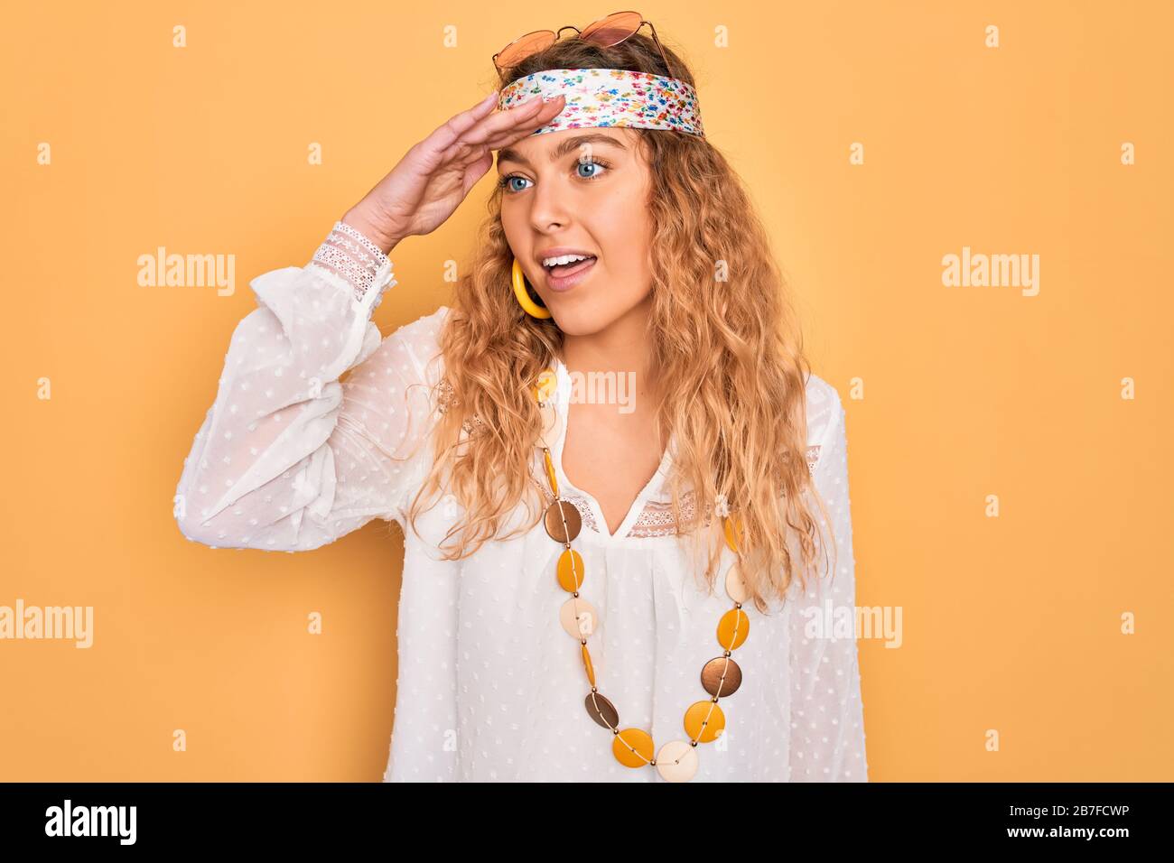 Young beautiful blonde hippie woman with blue eyes wearing sunglasses ...