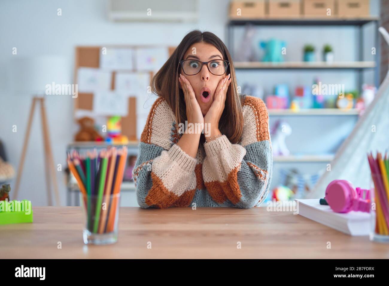 Young beautiful teacher woman wearing sweater and glasses sitting on ...