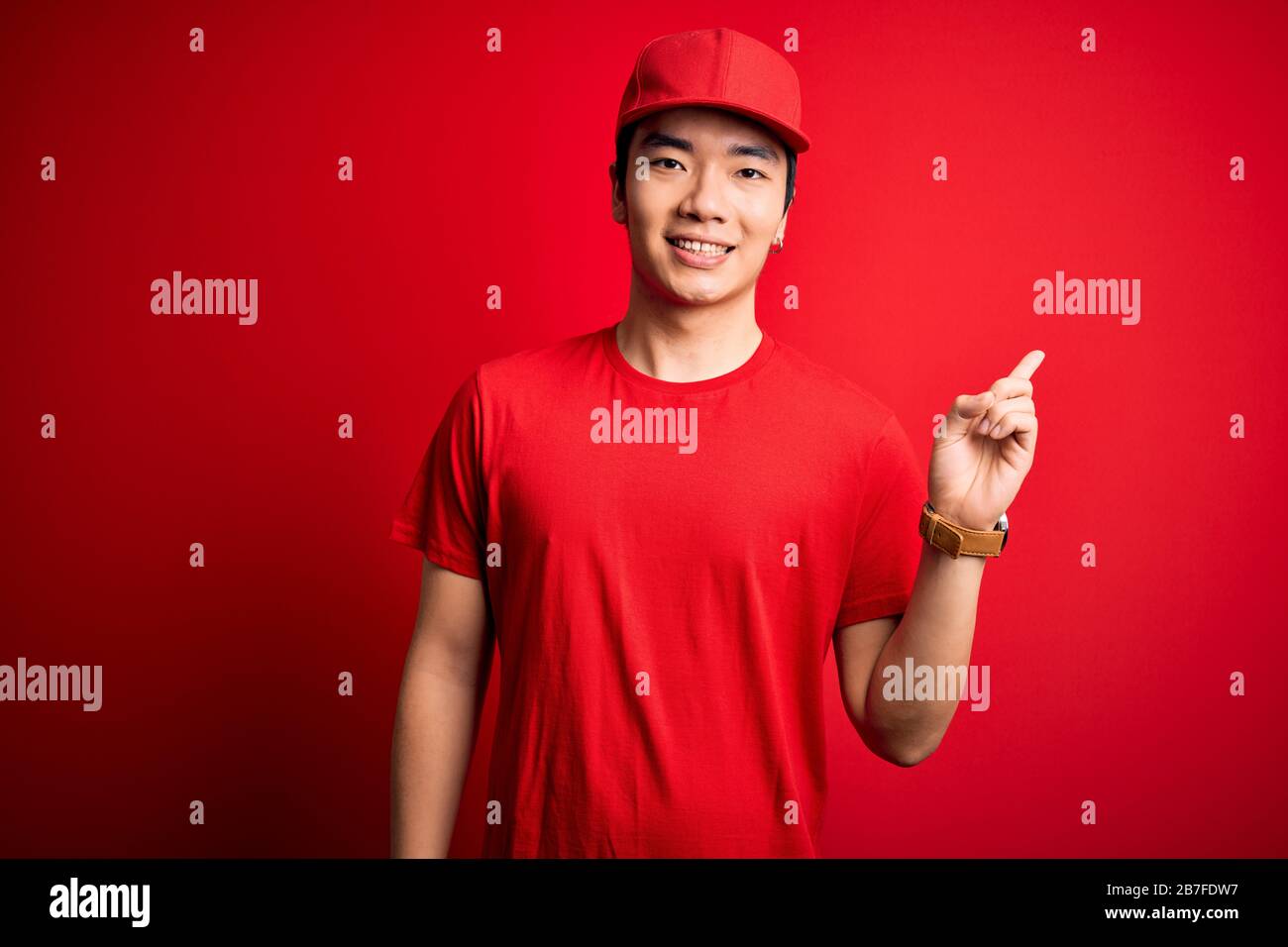 Young handsome chinese delivery man wearing cap standing over isolated ...