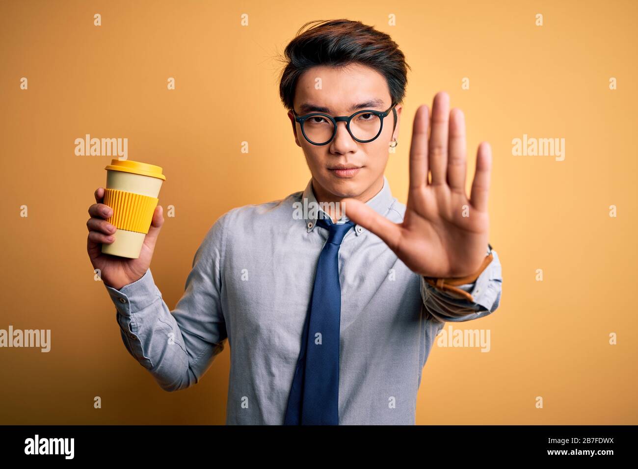 Young handsome chinese man drinking glass of take away coffee over ...