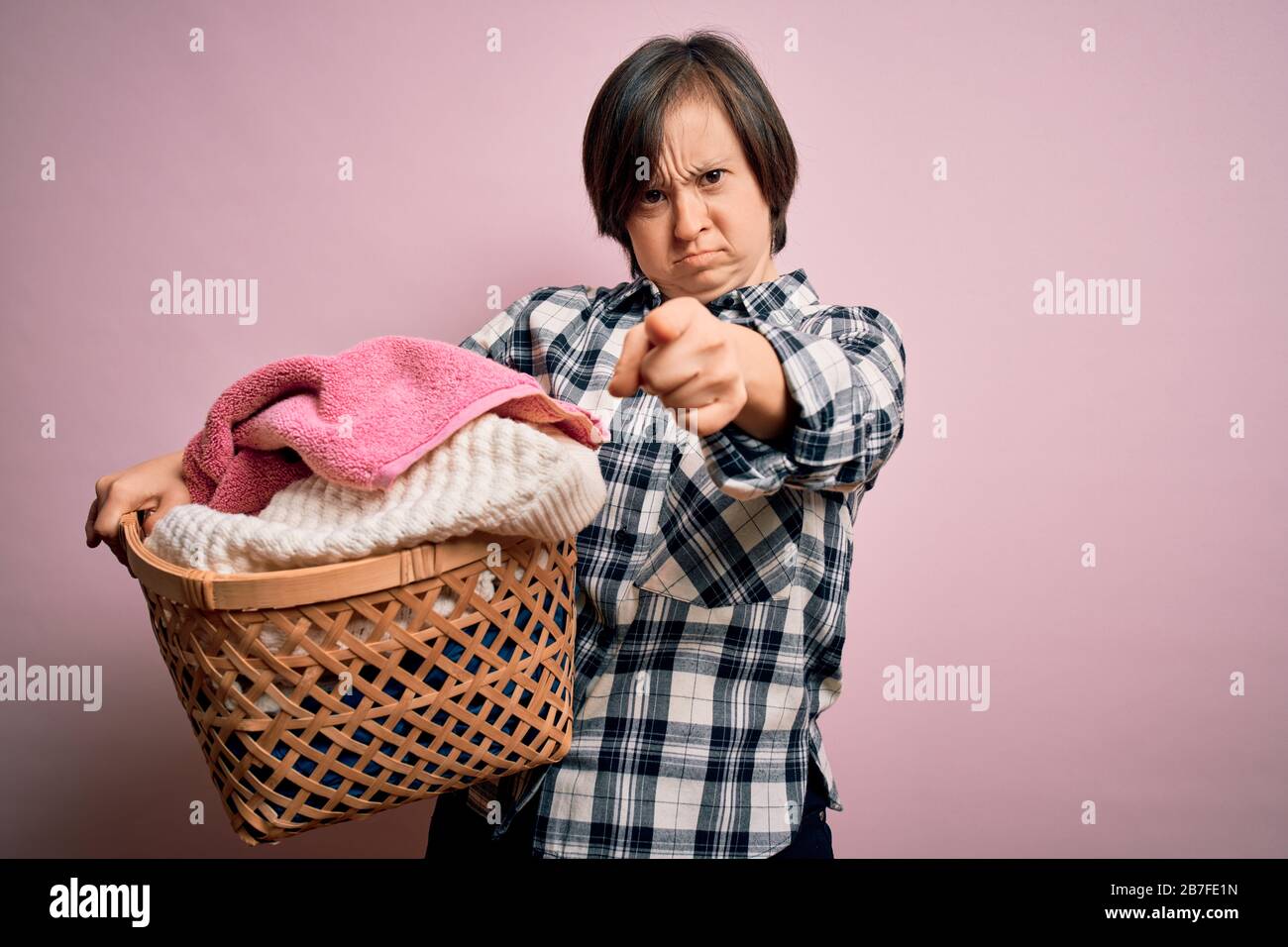 Young down syndrome woman doing housework domestic chores holding ...