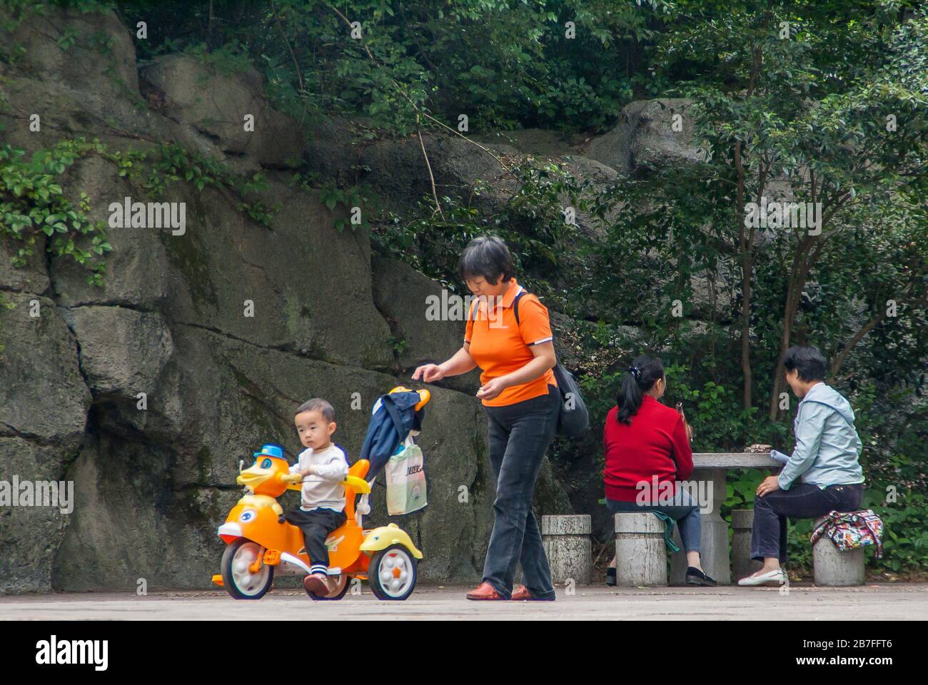 Guilin, China - May 11, 2010: Seven Star Park. Woman pushes toddler on ...