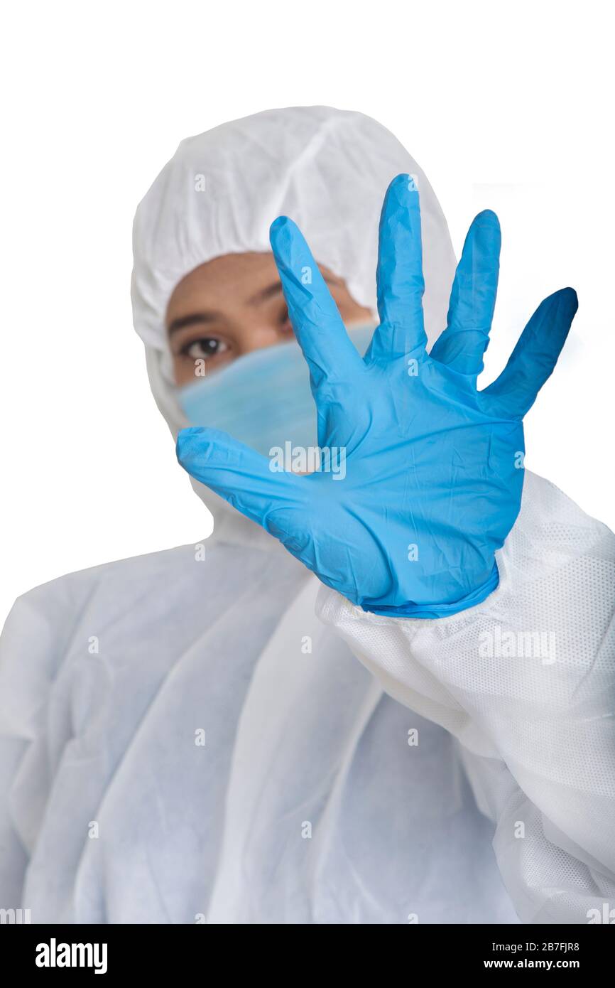 Female officer in protecive suit raise her hand as a sign to stop Stock ...