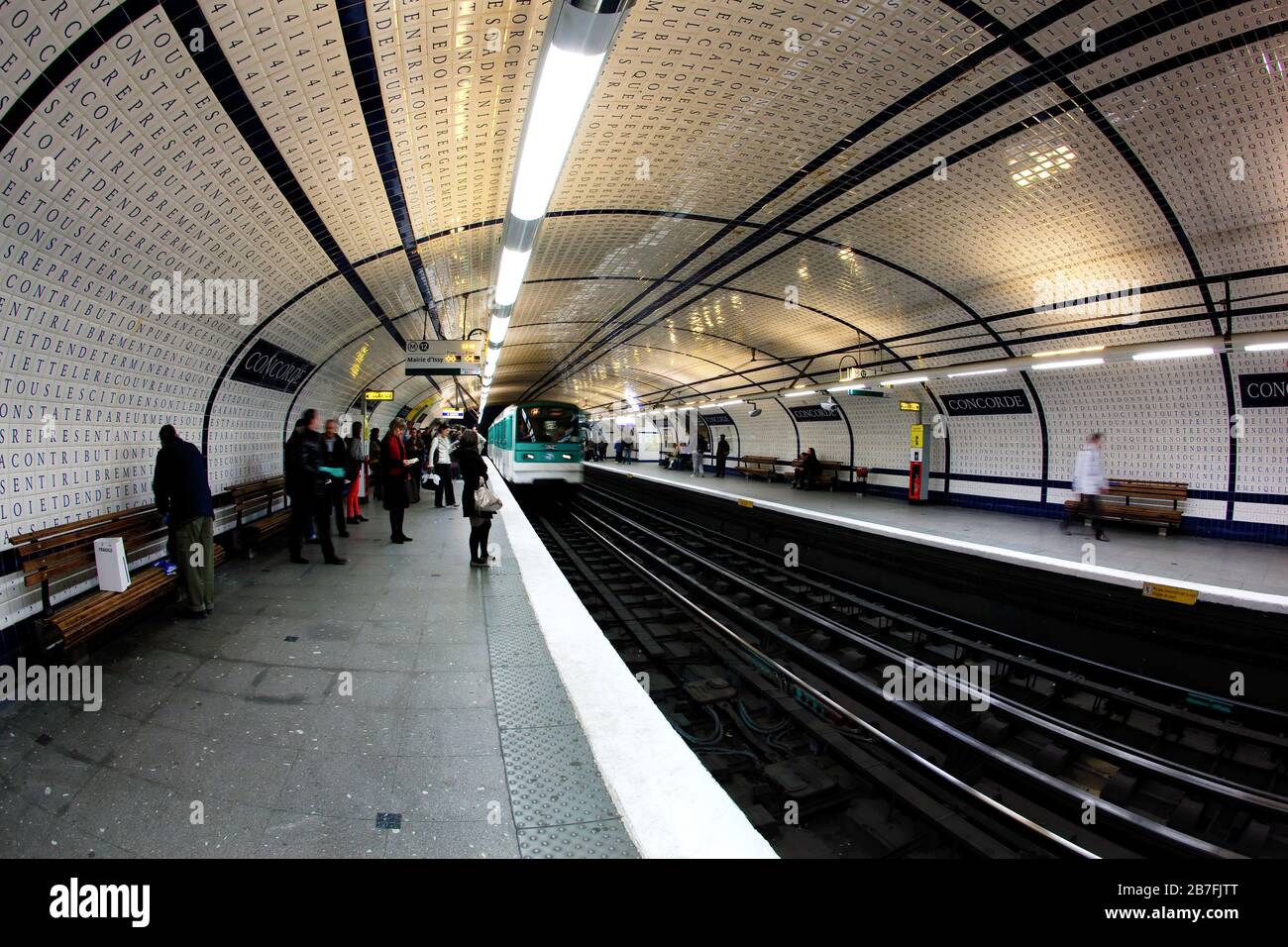 Passengers waiting for an arriving train at Concorde Metro station ...