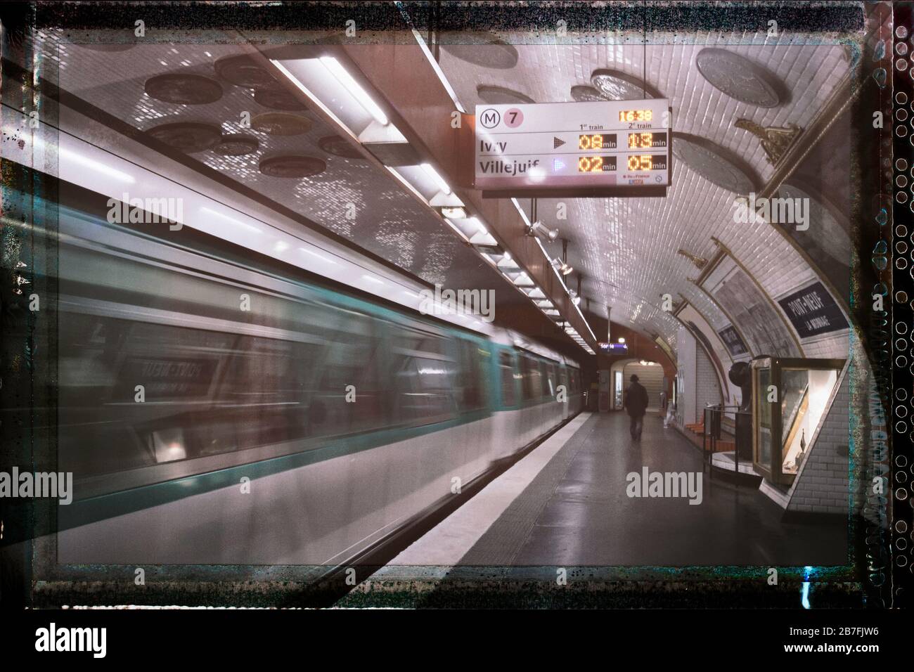 A train departs Pont Neuf La Monnaie Metro station as a passenger exits ...