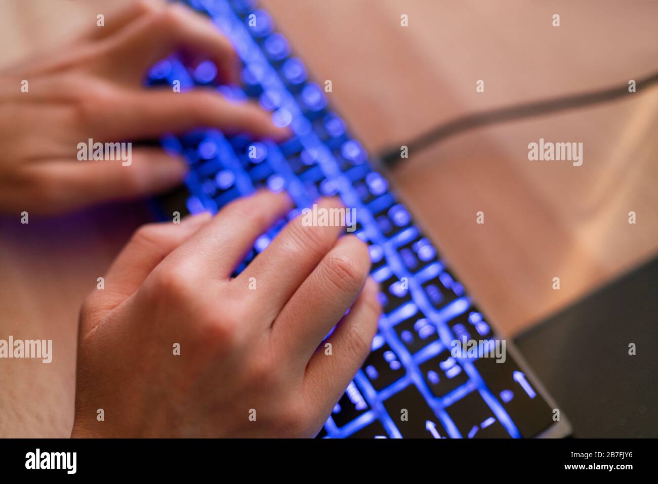 Gamer pc computer keyboard woman typing on blue backlit gaming key ...
