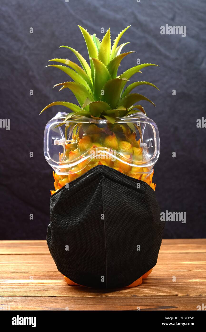 well protected pineapple wears a medical mask and an eye protector ...