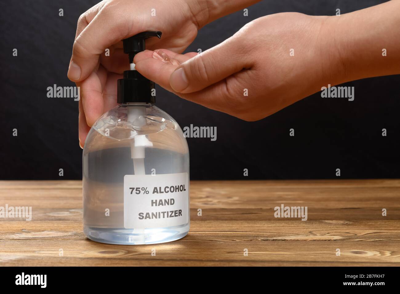 man using 75 percent alcohol instant hand sanitizer to clean his hands ...