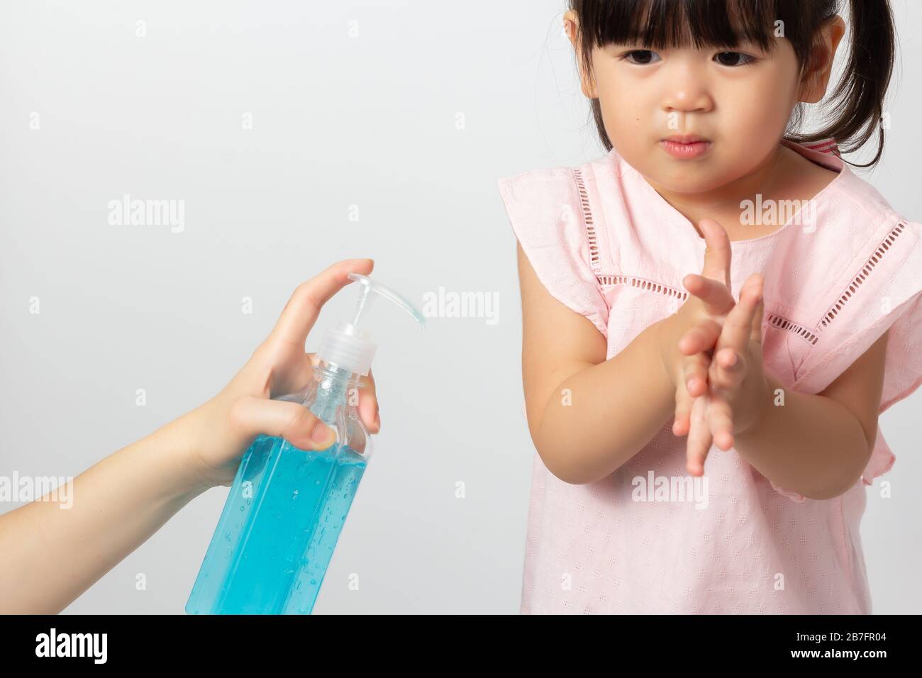 Asian Mom using alcohol antiseptic gel for cleaning baby hands to ...