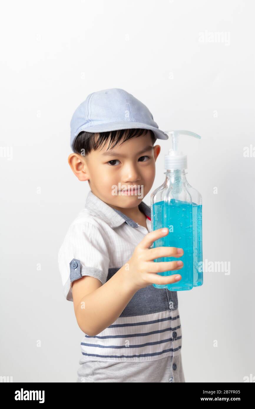 Asian boy holding bottle of alcohol gel for cleaning baby hands to ...
