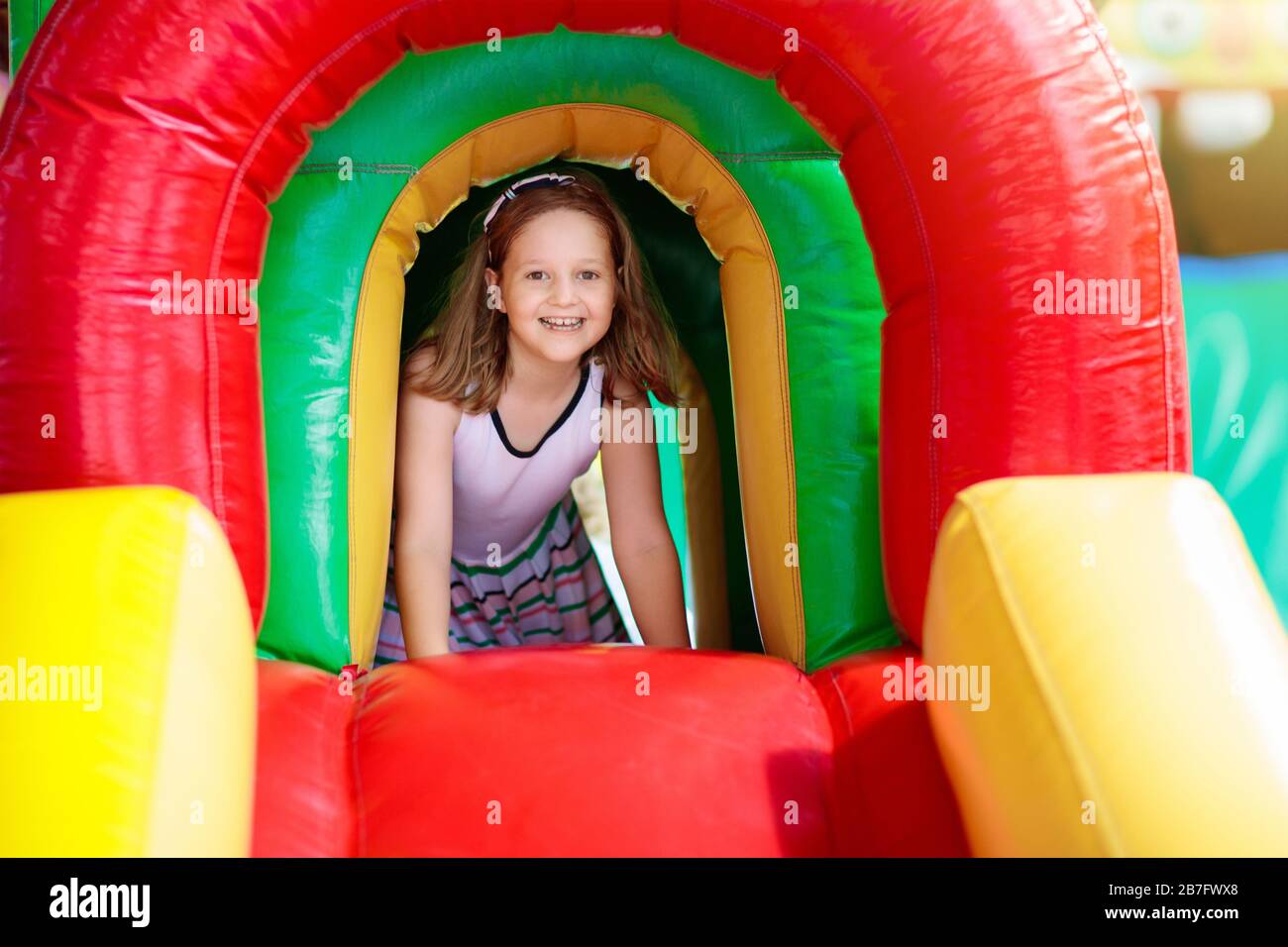 Child jumping on colorful playground trampoline. Kids jump in ...
