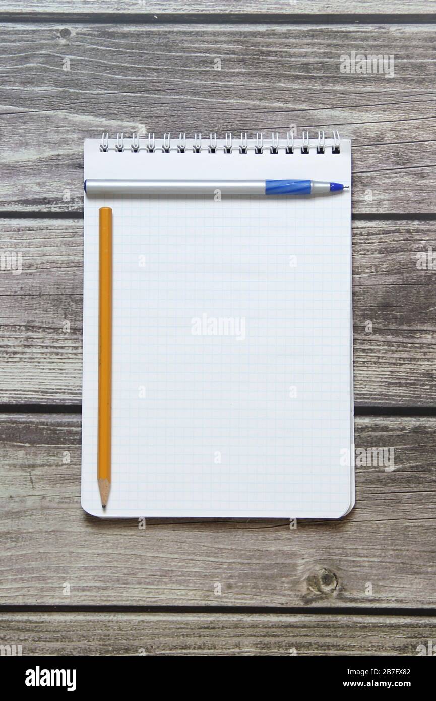 Notepad with a blank white sheet in a checker paper with ball pen and ...
