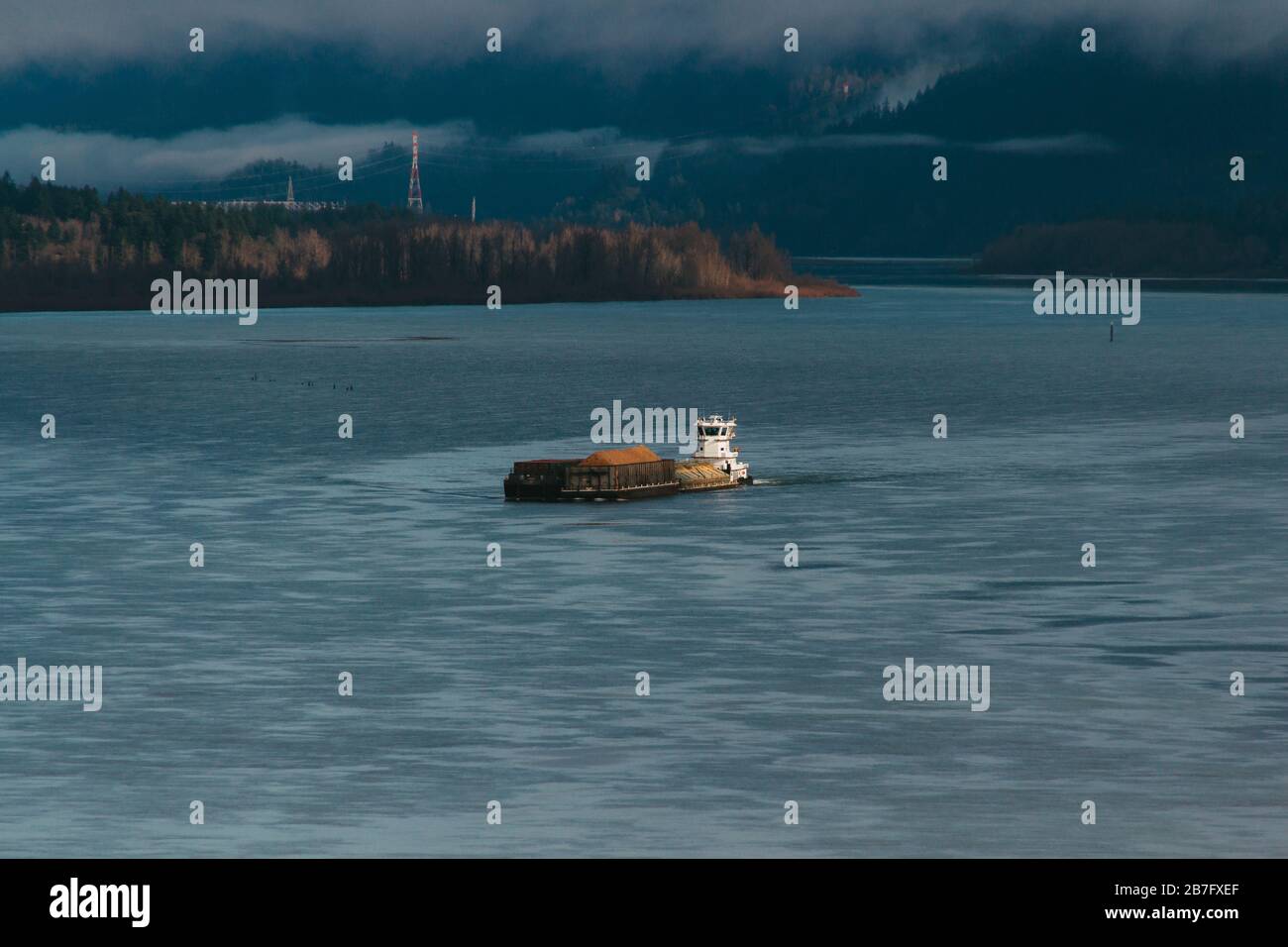 Wide angle shot of a cargo ship with a tower on top surrounded by ...