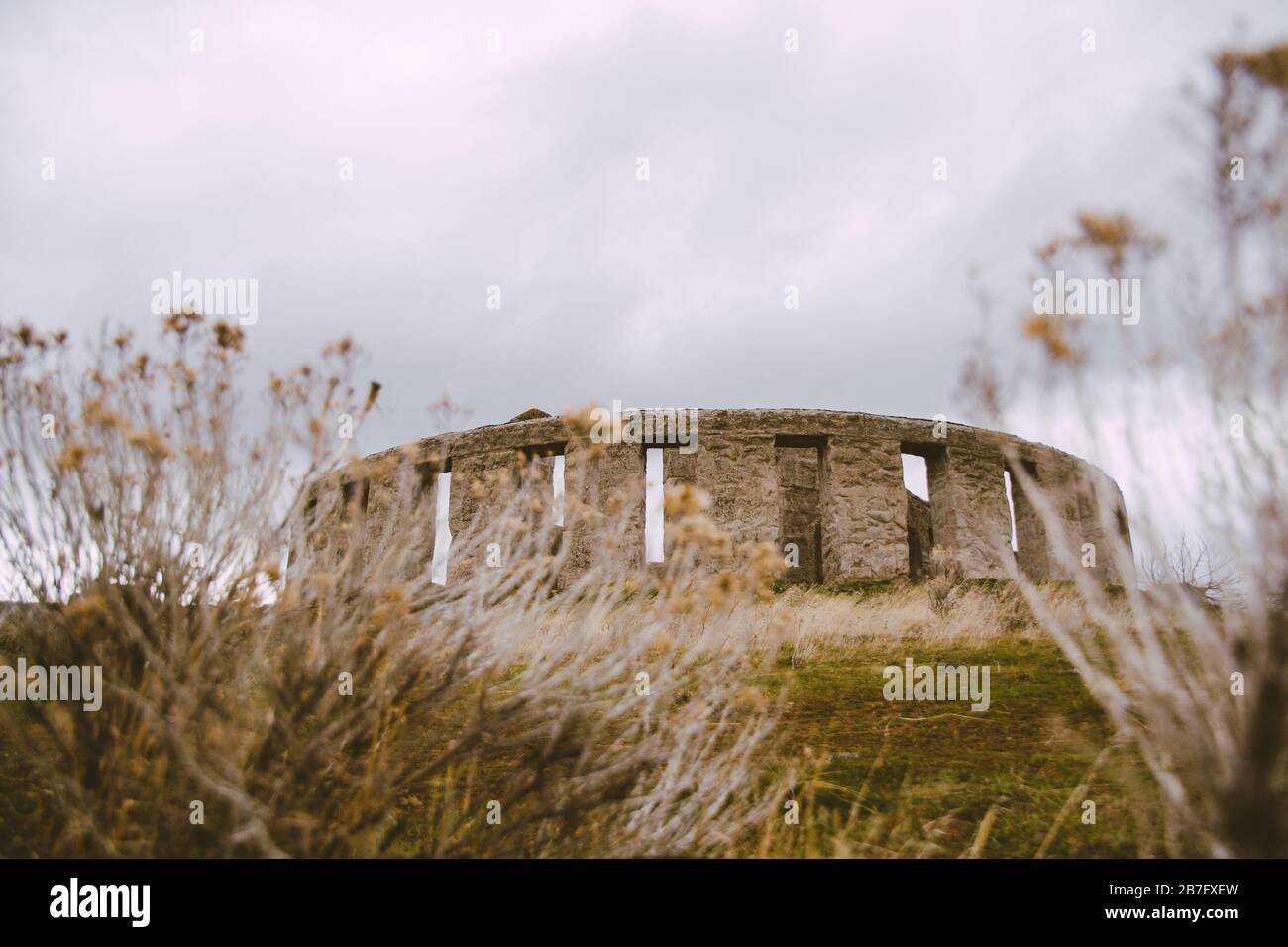 Circular ancient building made out of stone surrounded by grass Stock ...