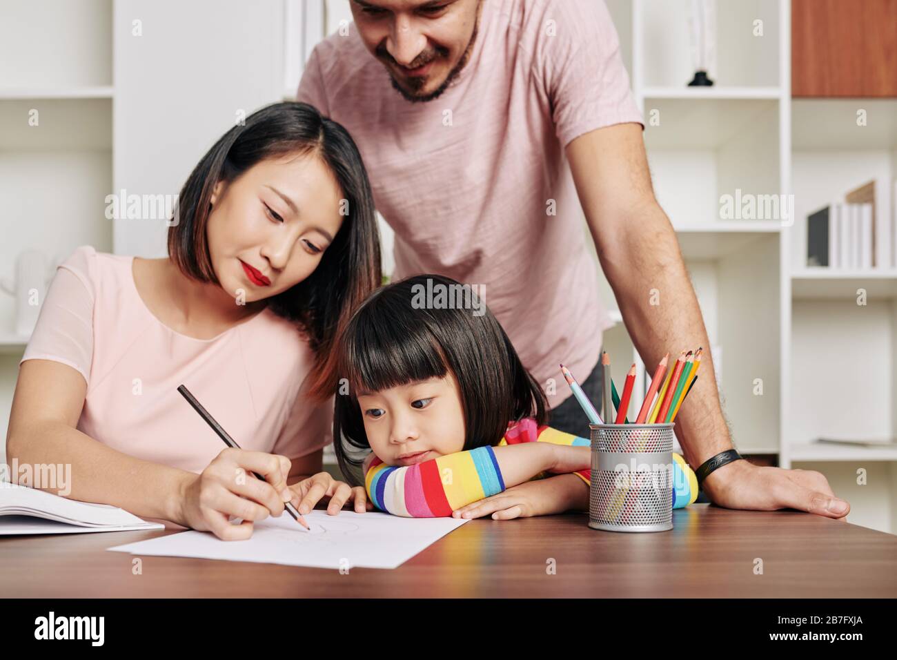 Parents explaining daughter difficult topic and drawing something on ...