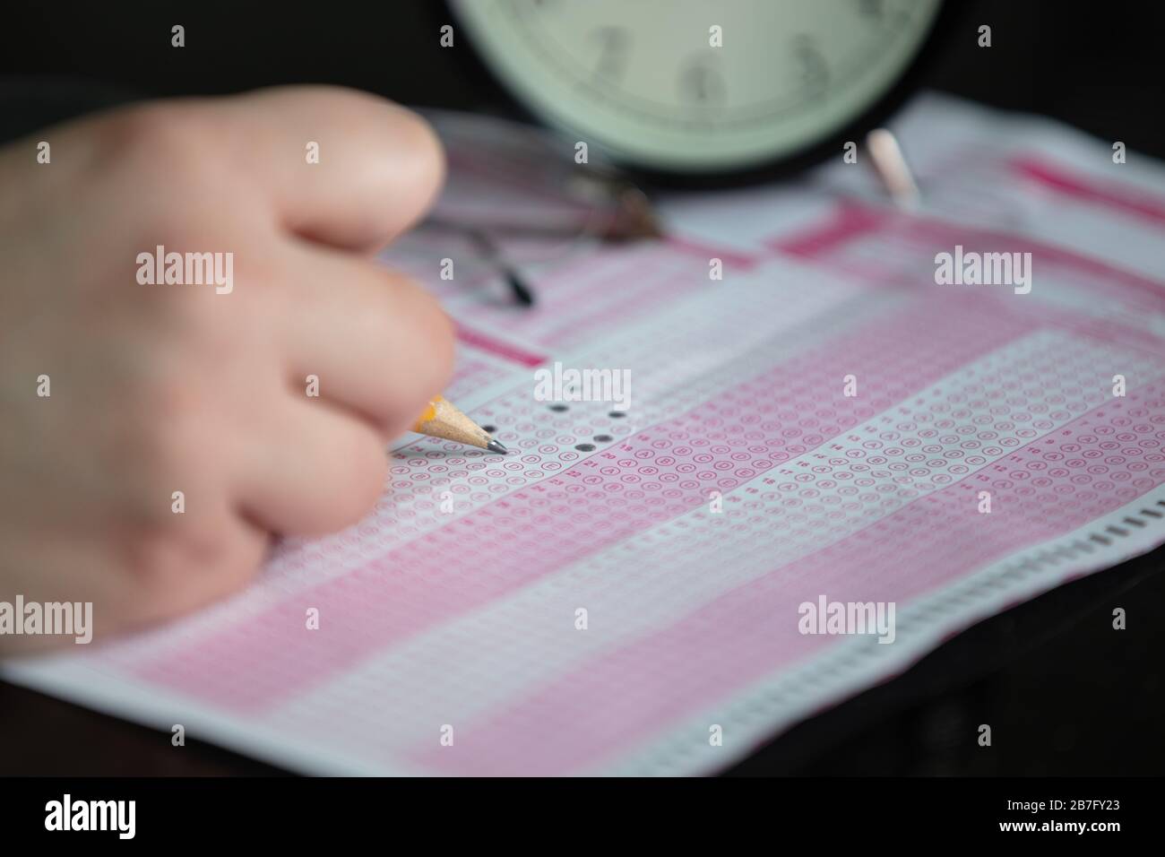 Person filling in a checklist next to a table watch - time management ...