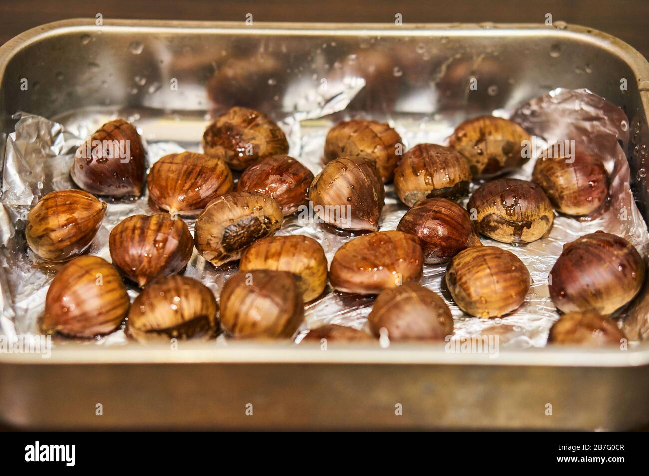 Metal pan filled with a lot of edible chestnuts Stock Photo - Alamy