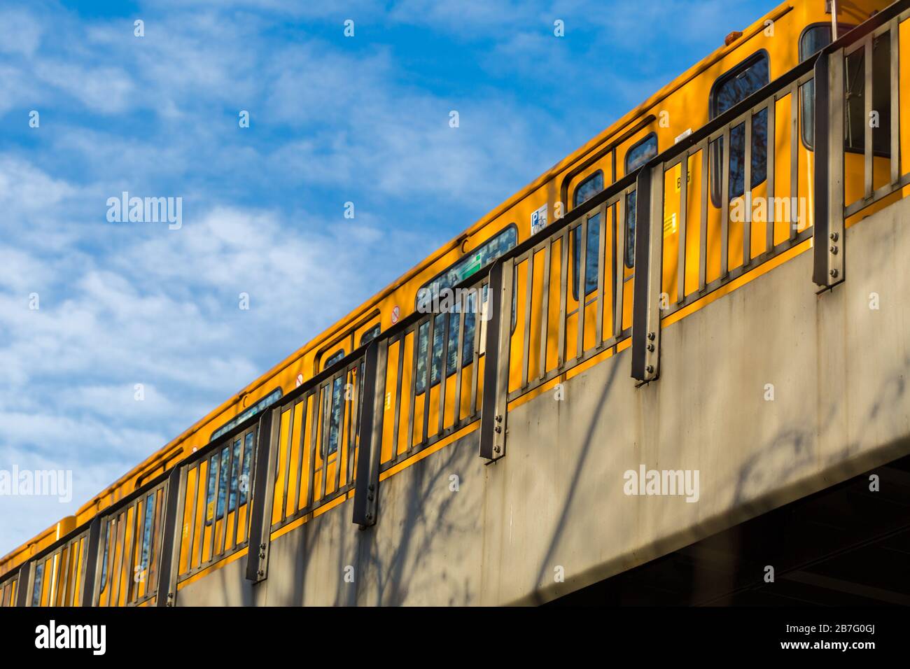 Yellow U-Bahn train crossing a bridge at Böcklerpark (Close to ...