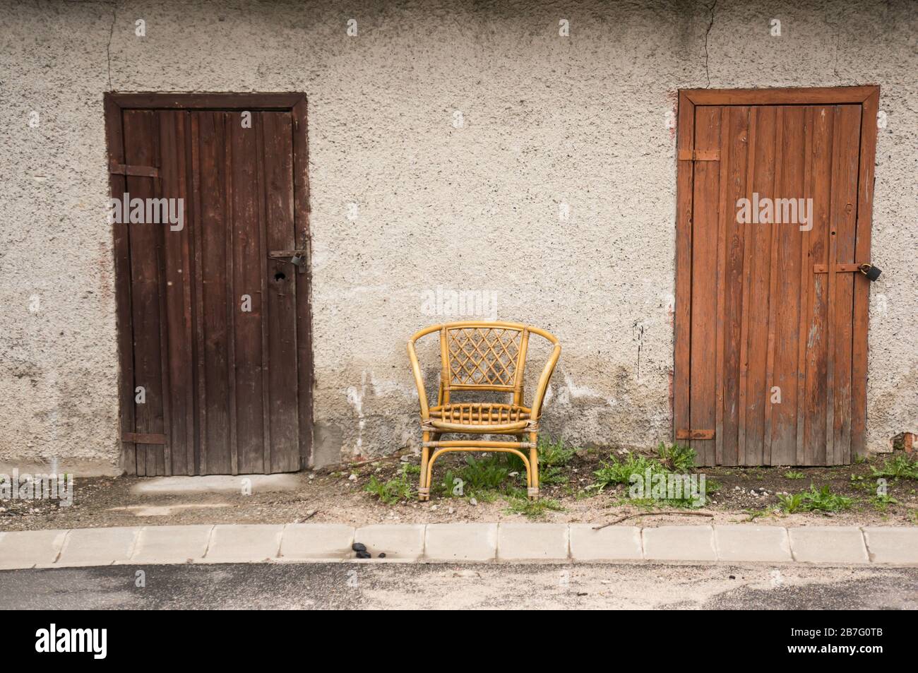 Wooden chair between two doors in the garden Stock Photo - Alamy