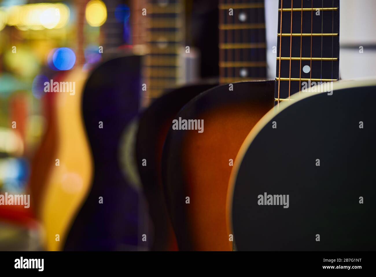Row of classic acoustic guitars in the store Stock Photo - Alamy
