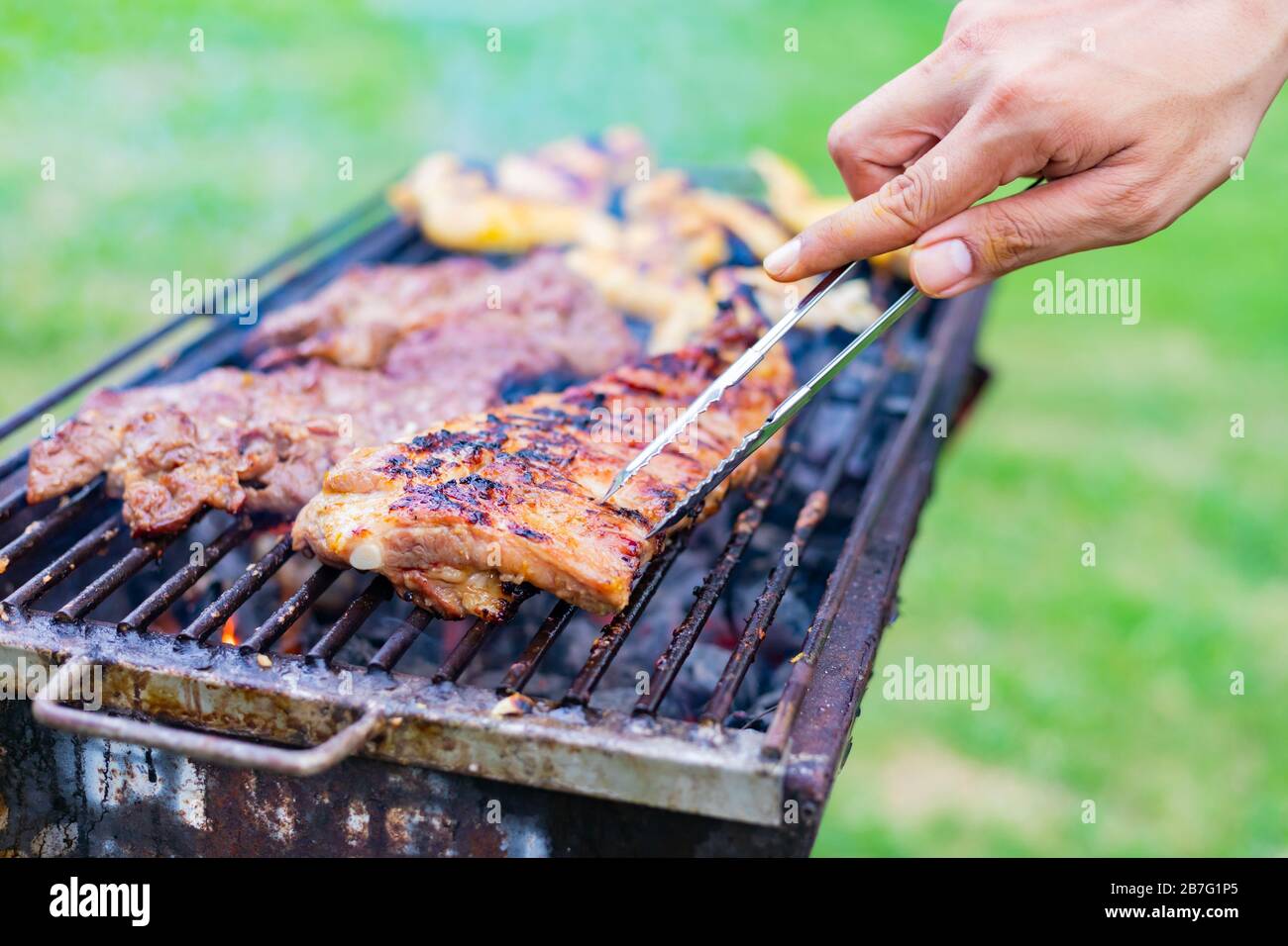 Cooking BBQ meat at festival outdoor in park. Concept of summer party ...