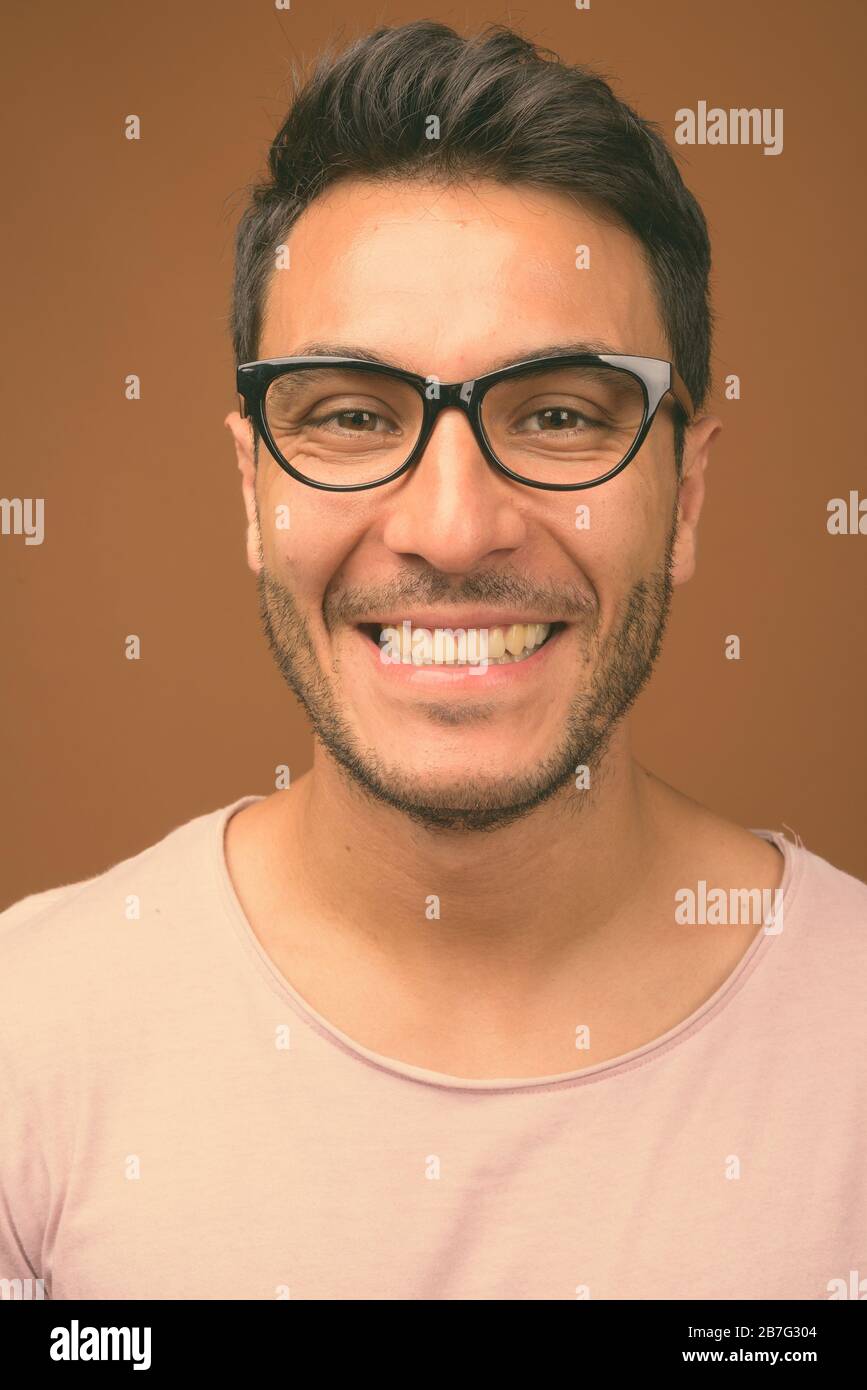 Young handsome Hispanic man against brown background Stock Photo - Alamy
