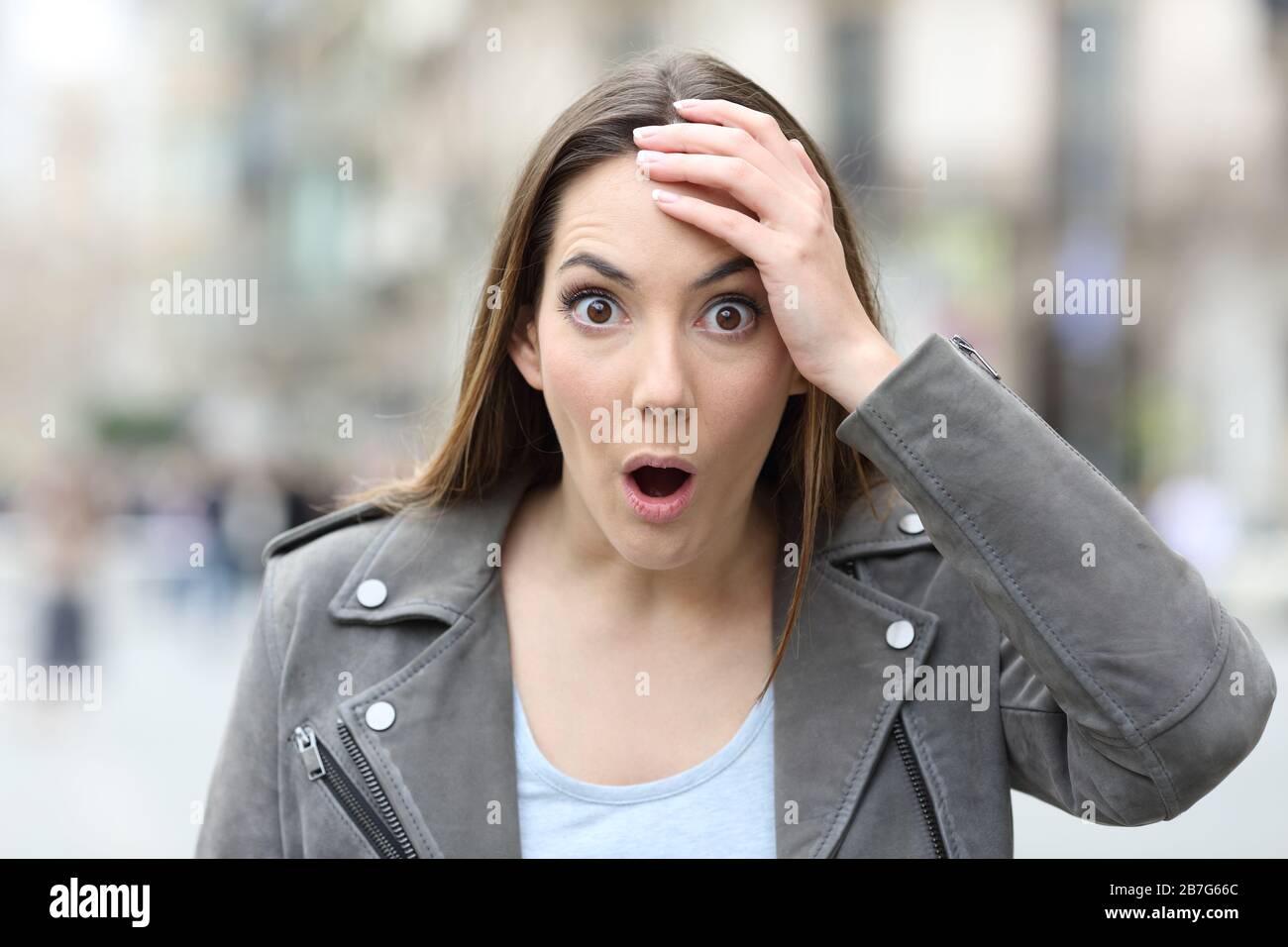 Front view portrait of an amazed woman looking at camera with hand on ...