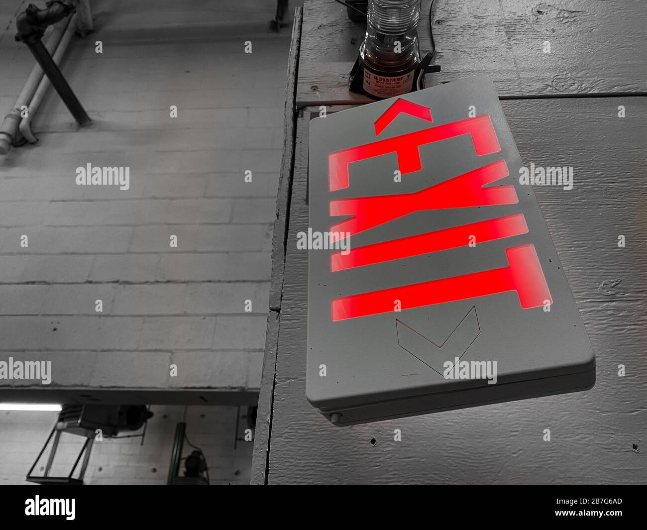 A Broken Sideways Hanging Red Exit Sign Stock Photo - Alamy