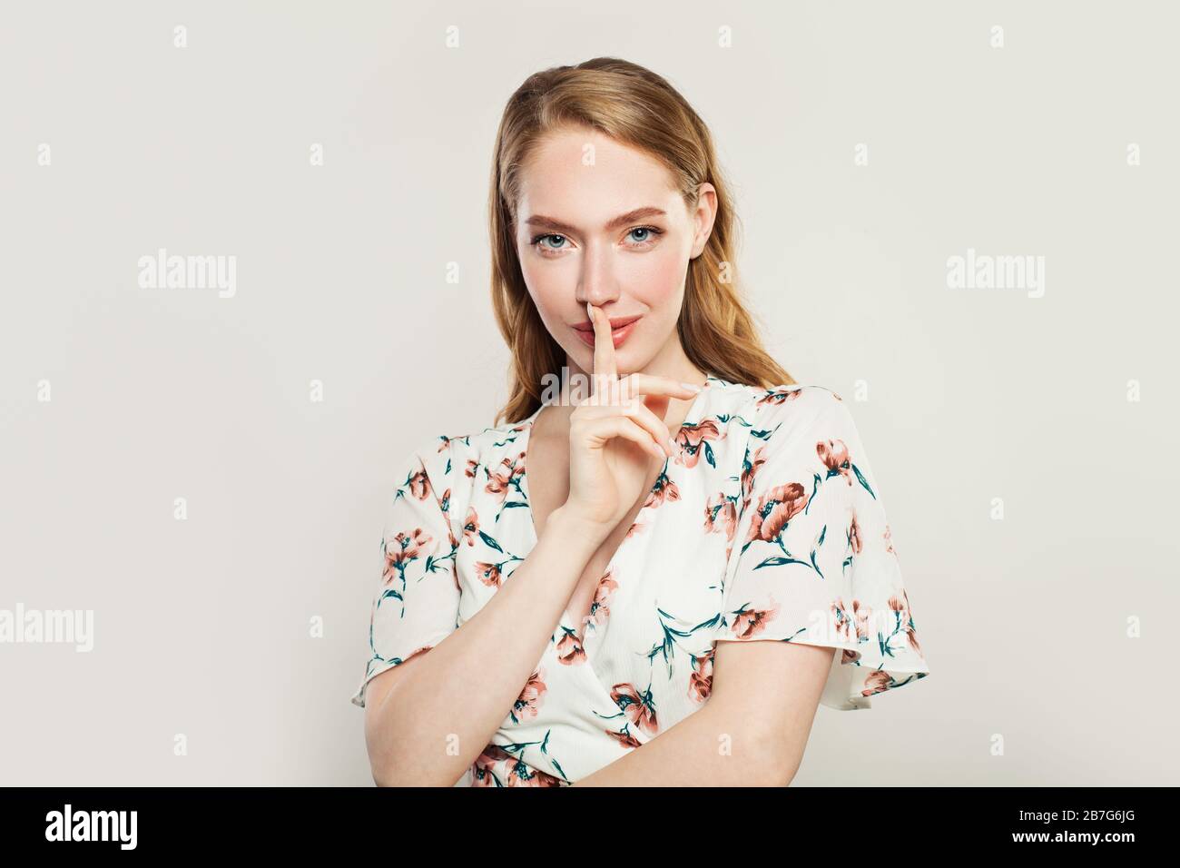 Woman with silence gesture on white background Stock Photo - Alamy