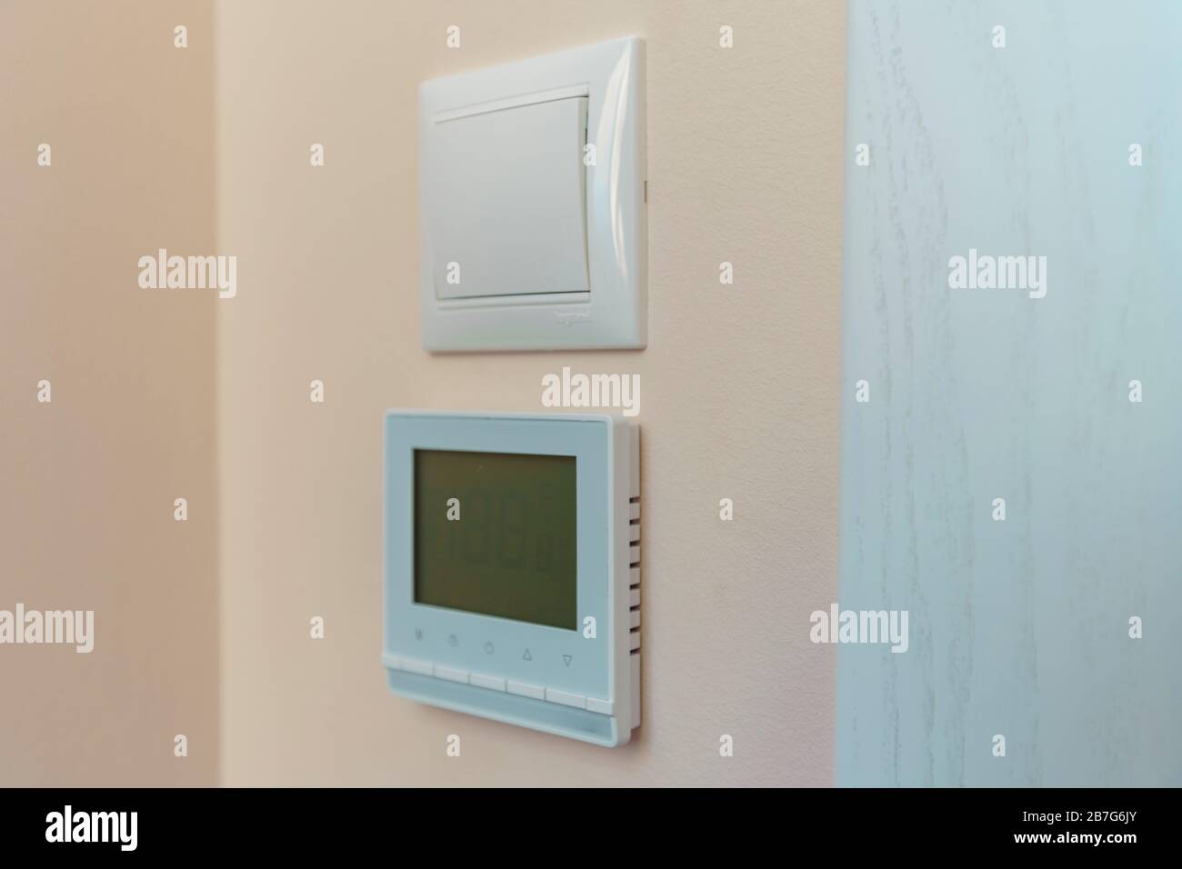 on the wall of the room there is a light switch and under it a floor ...